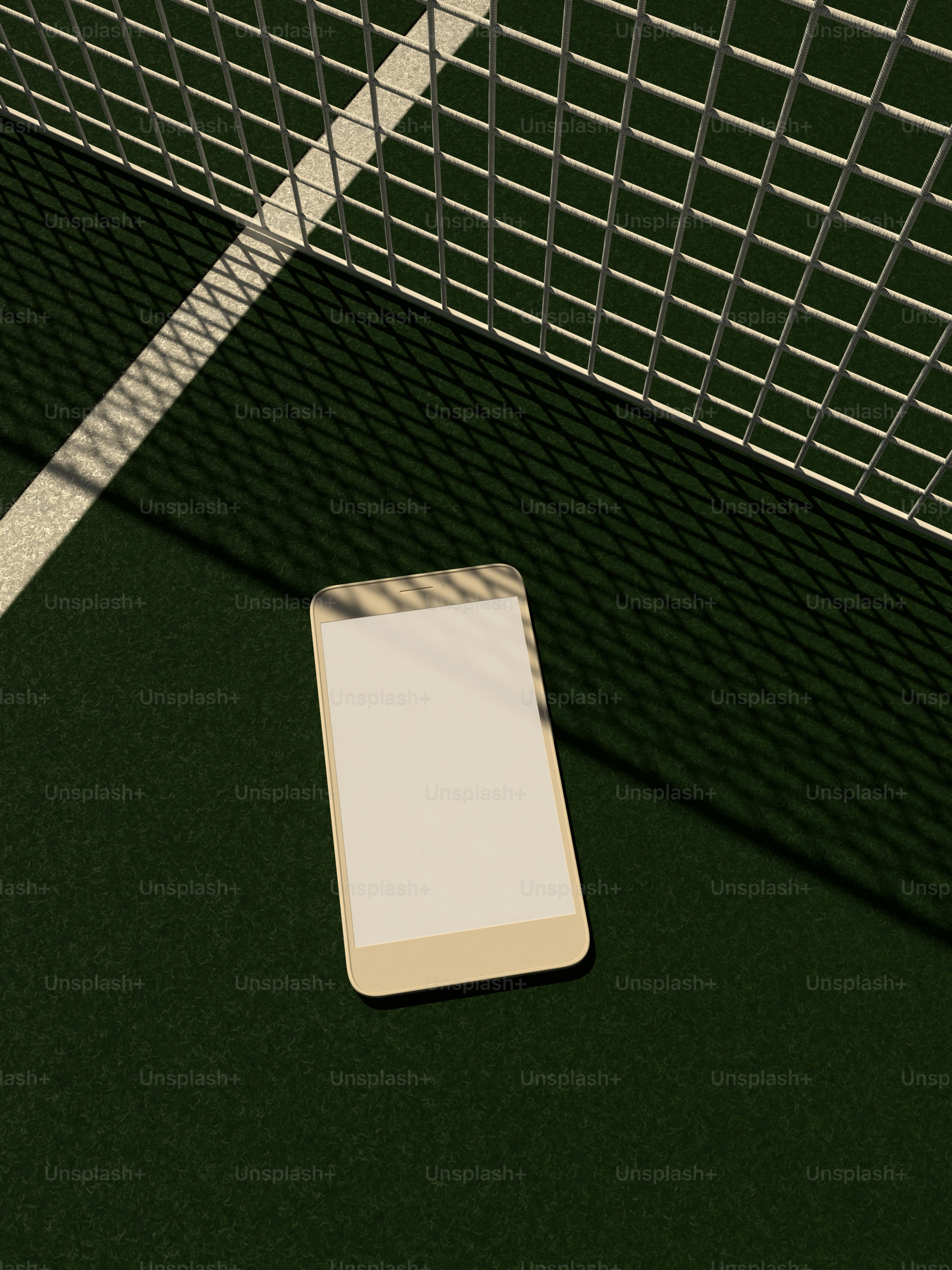 A cell phone laying on the ground in front of a fence photo – Tennis ...