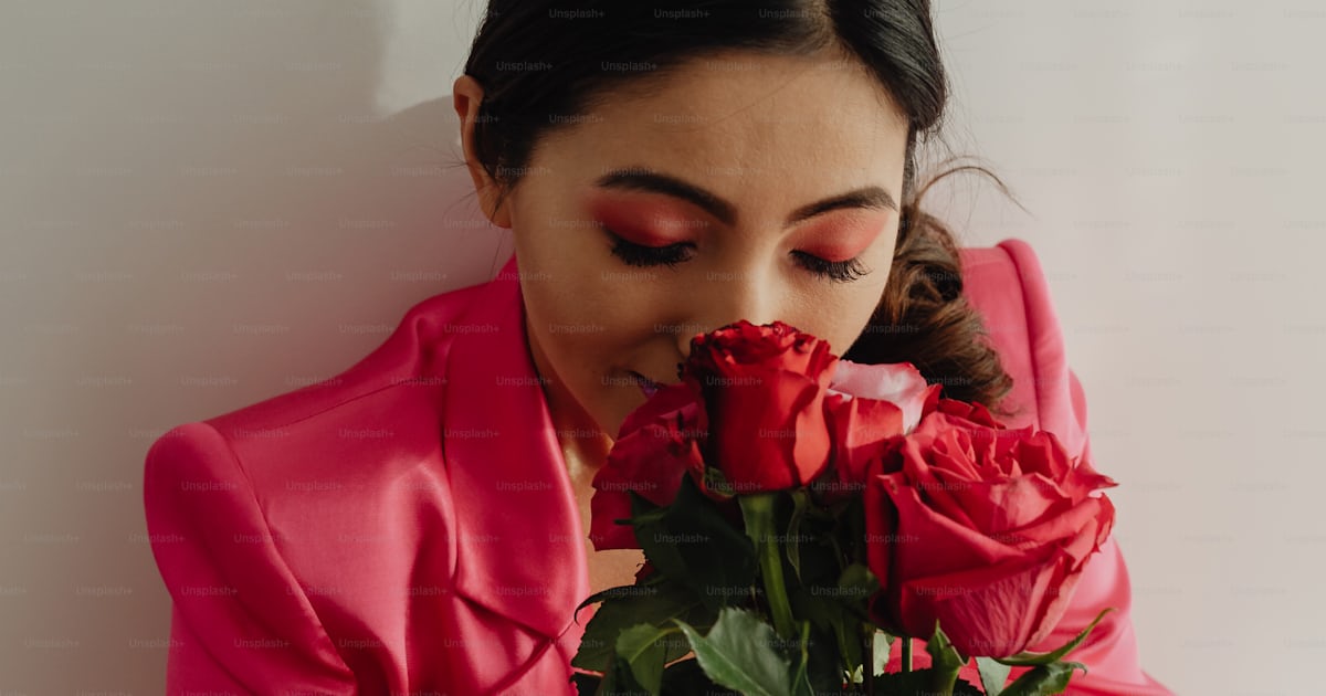 Foto Uma Mulher Em Um Terno Rosa Segurando Uma Rosa Vermelha Imagem De Fêmea No Unsplash