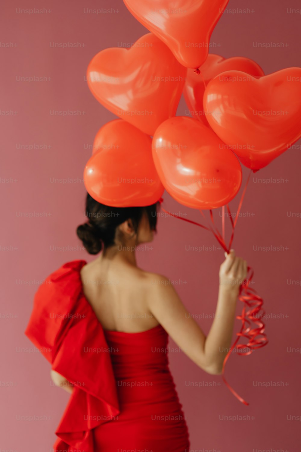 Foto zum Thema Eine Frau in einem roten Kleid, die einen Haufen ... Foto zum Thema Eine Frau in einem roten Kleid, die einen Haufen ...