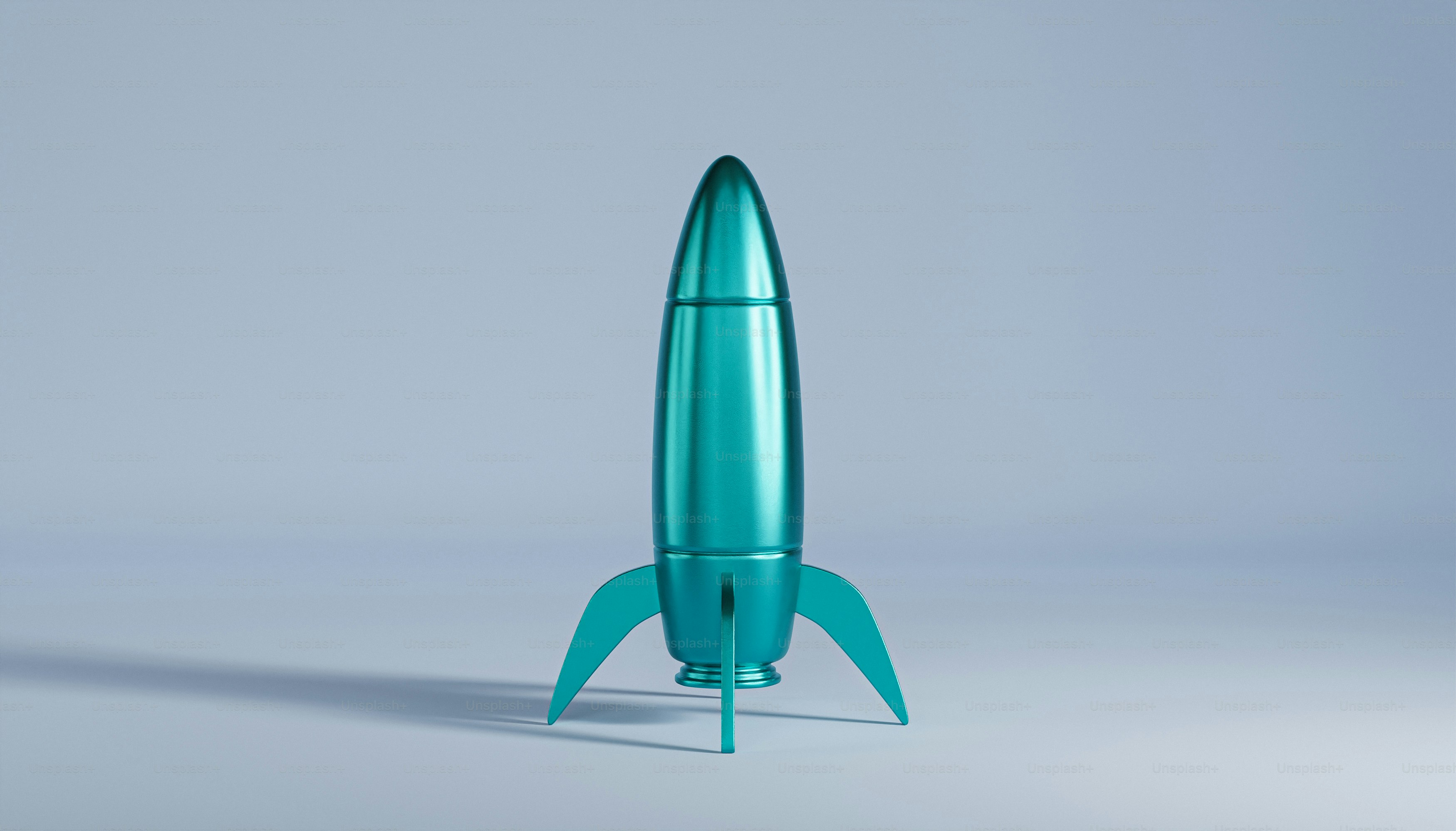 A blue rocket ship sitting on top of a table photo – Rocket Image on ...