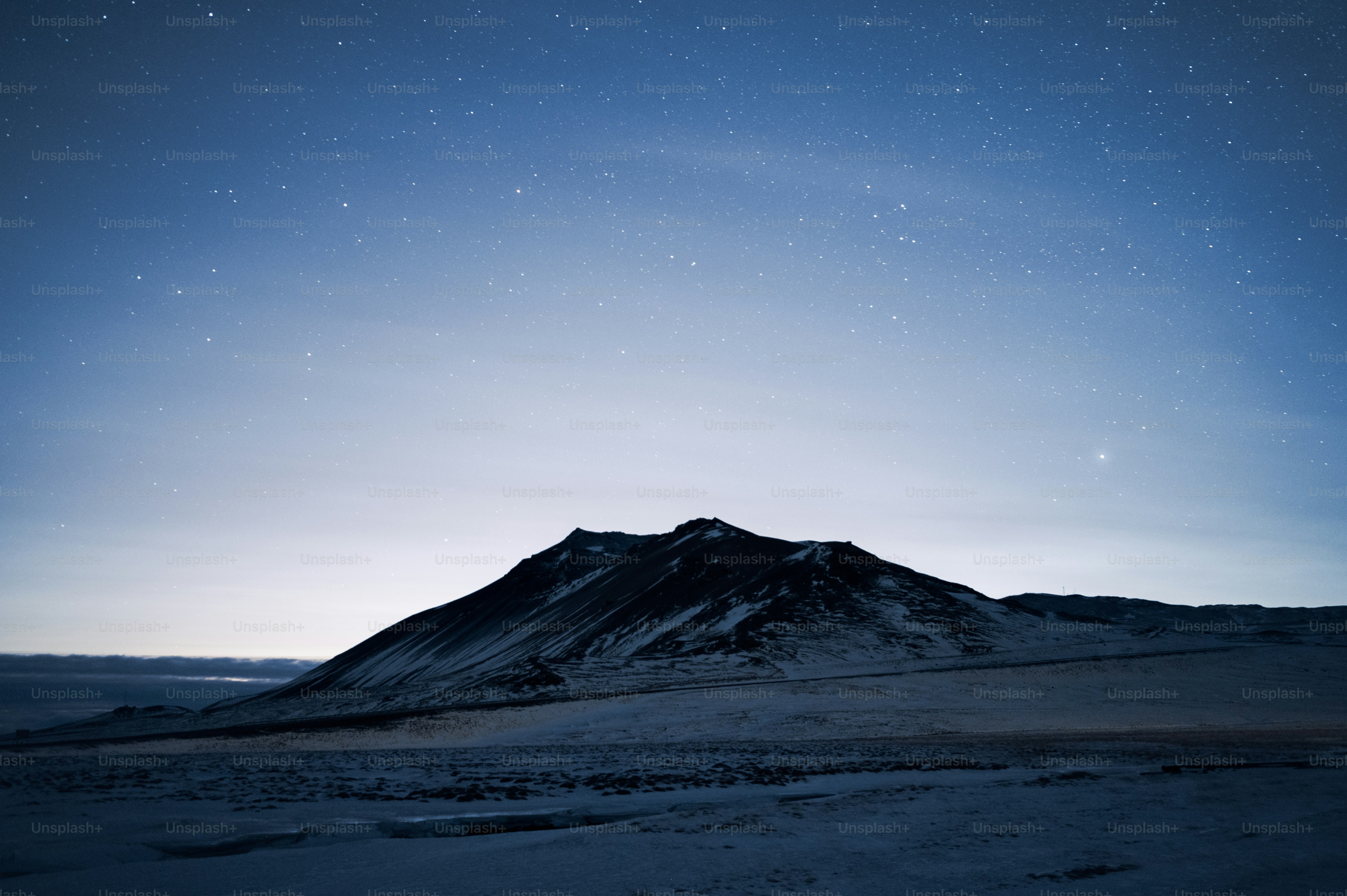 The night sky over a snow covered mountain photo – Mountain silhouette ...