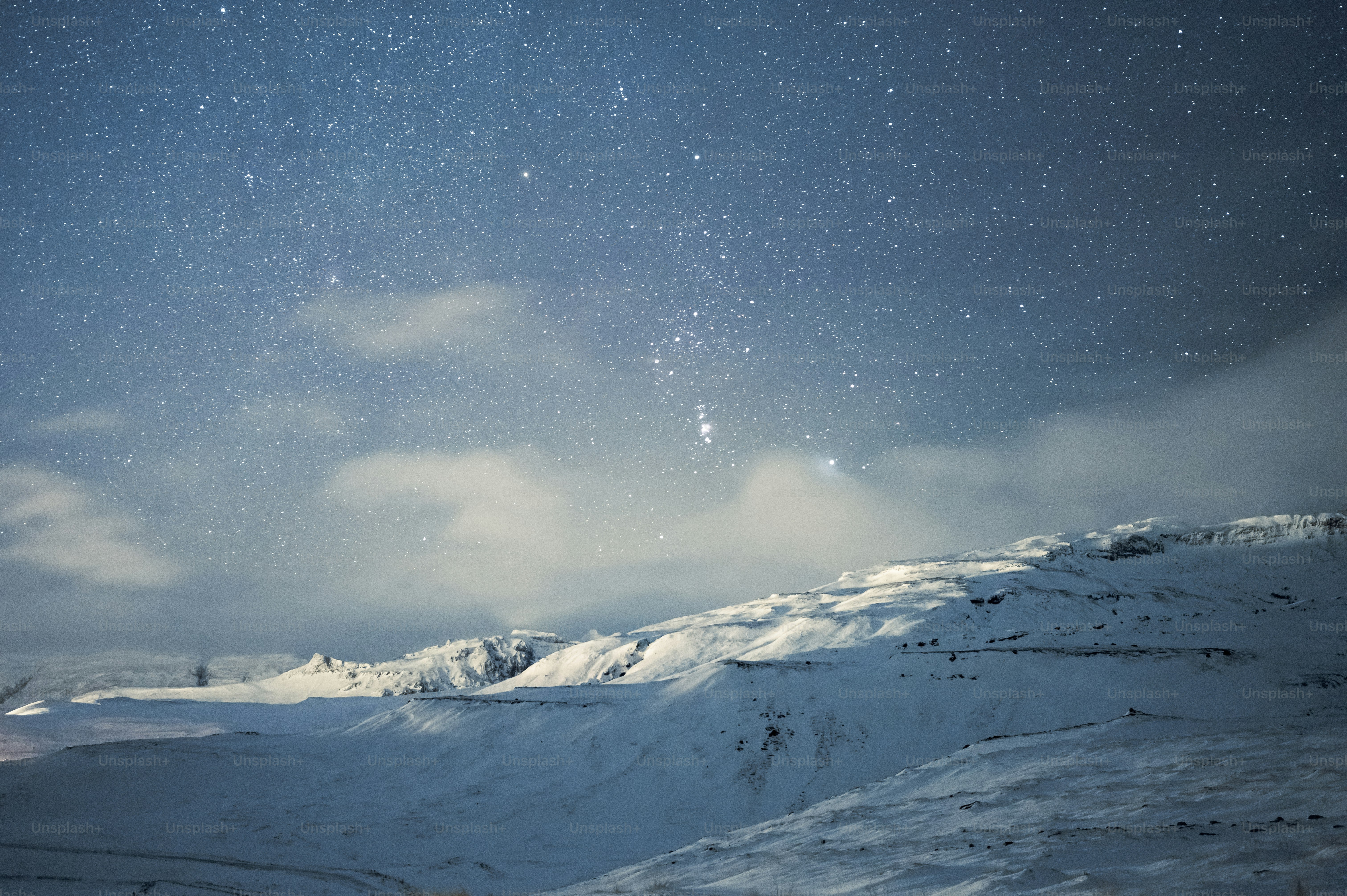 A mountain covered in snow under a night sky photo – Winter Image on ...