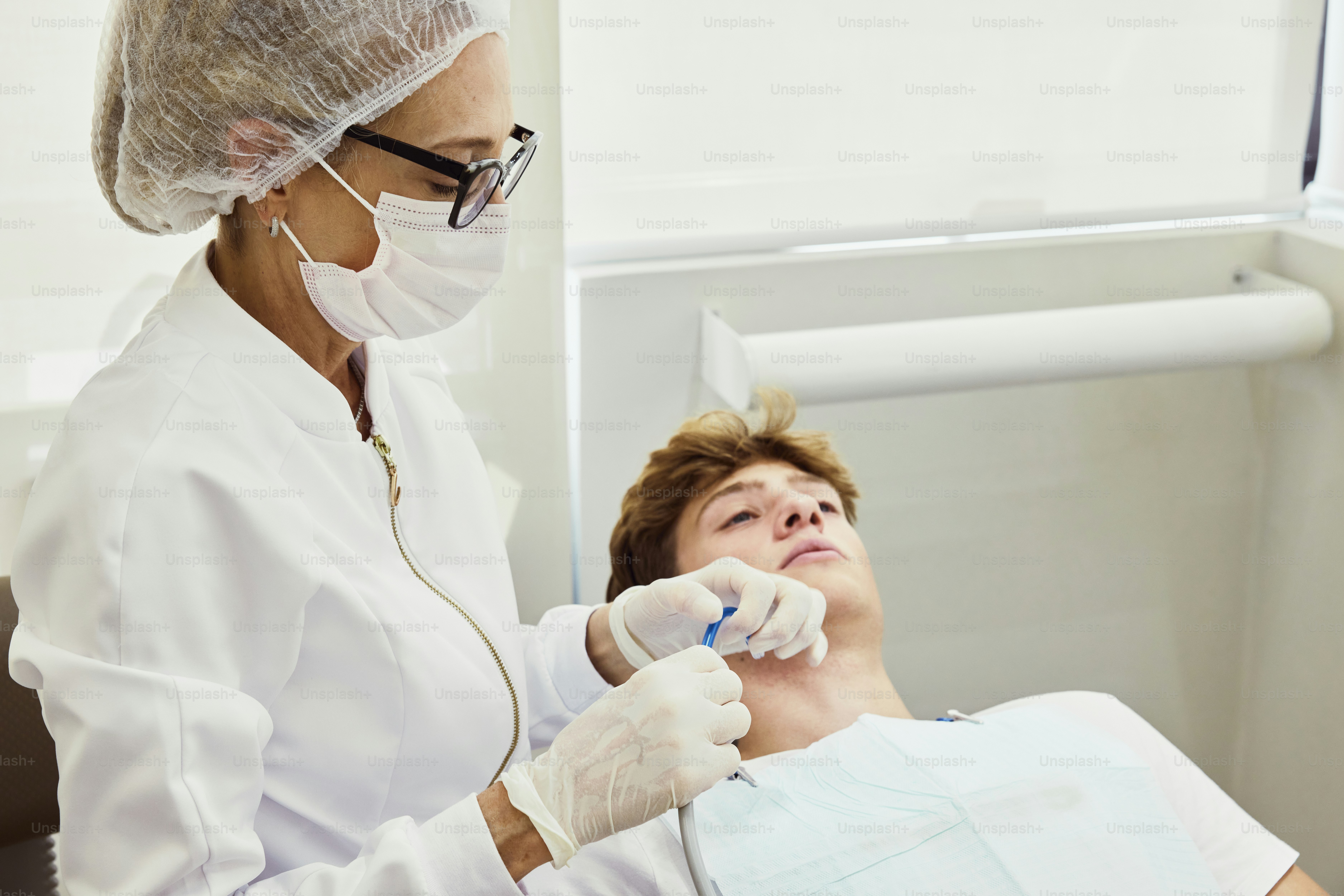 A woman getting her teeth checked by a dentist photo – Dentist Image on ...