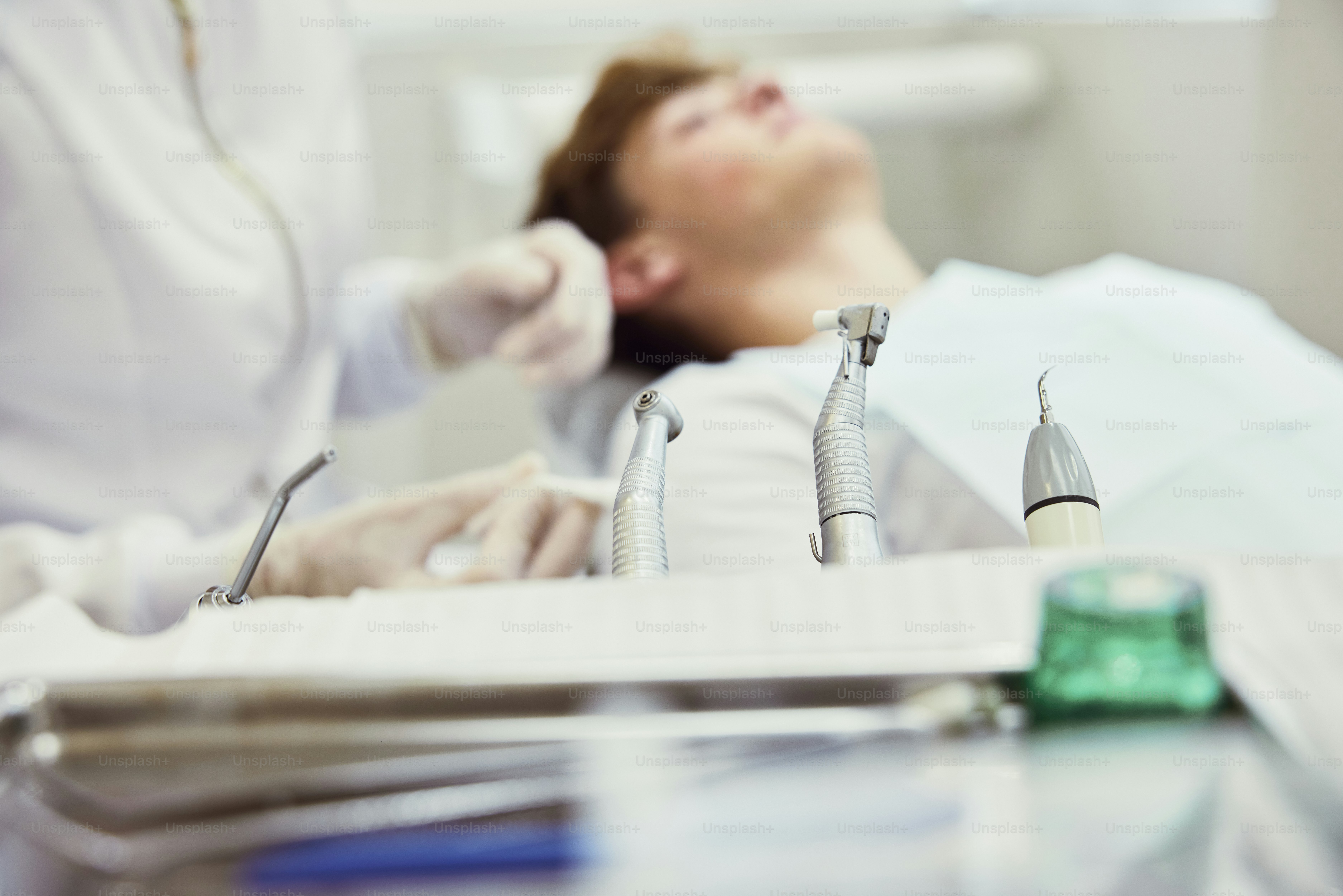 A woman laying in a hospital bed with dental equipment photo – Woman ...