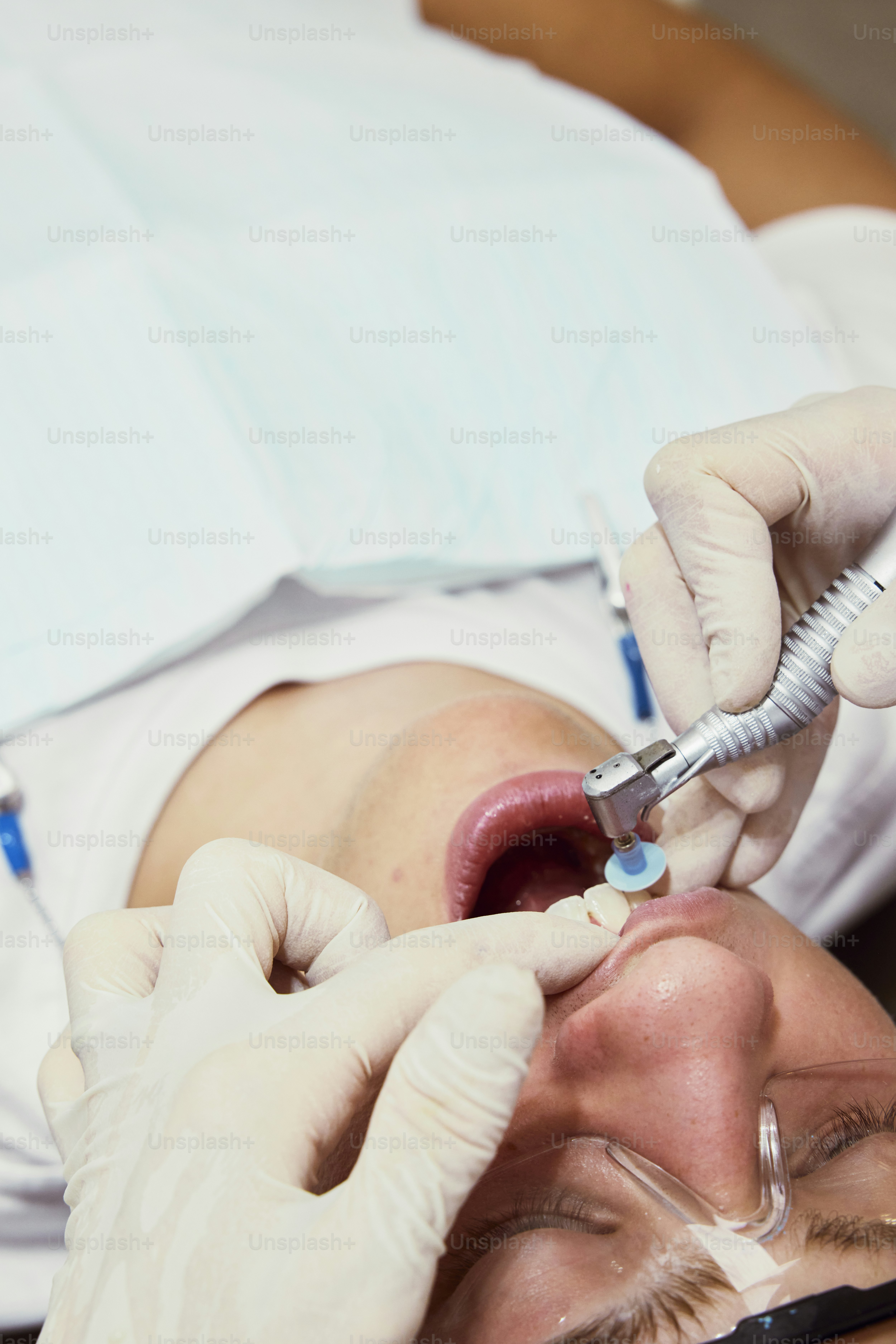 A man getting his teeth checked by a dentist photo – Woman Image on ...