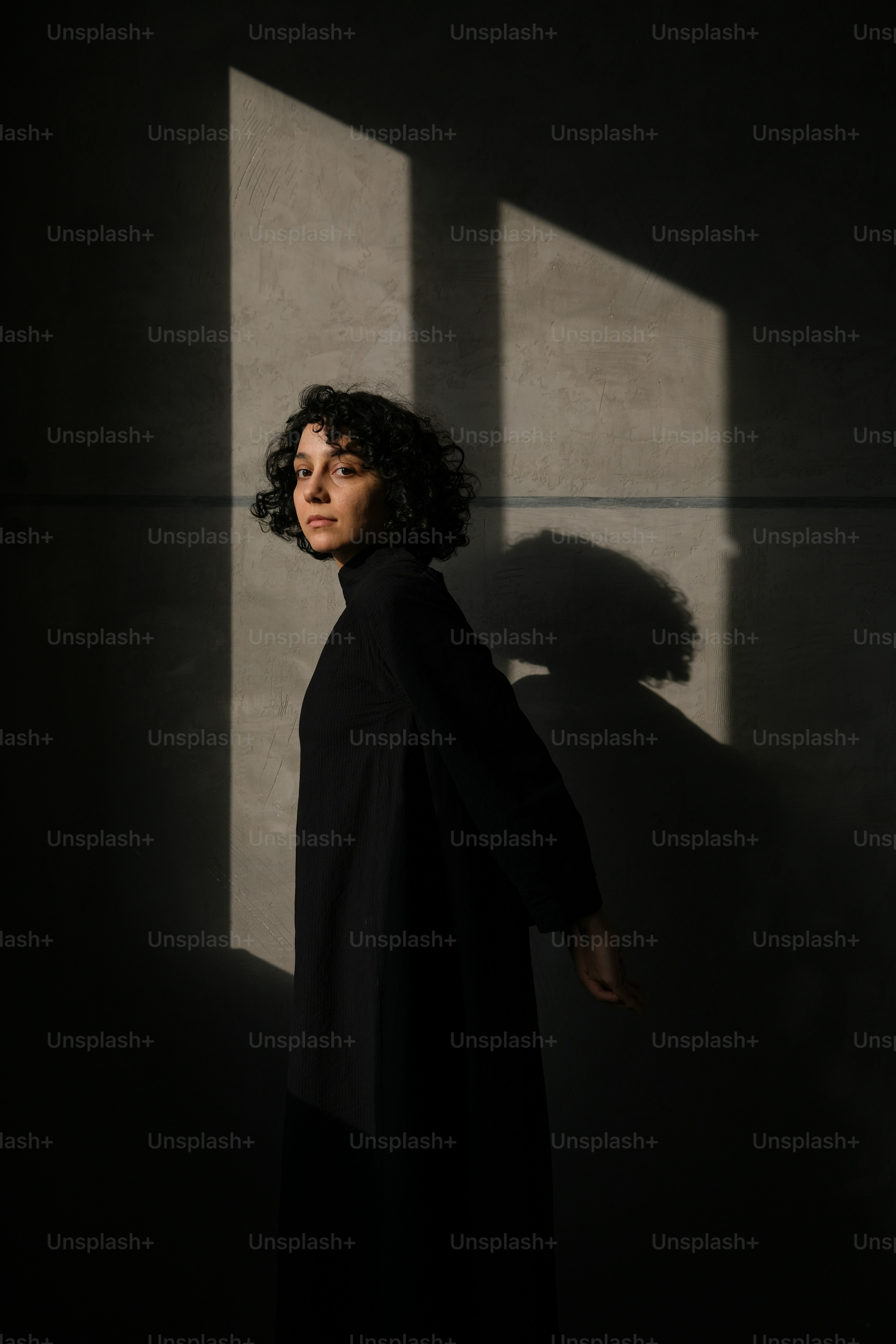 A woman standing in the shadows of a wall photo – Style Image on Unsplash