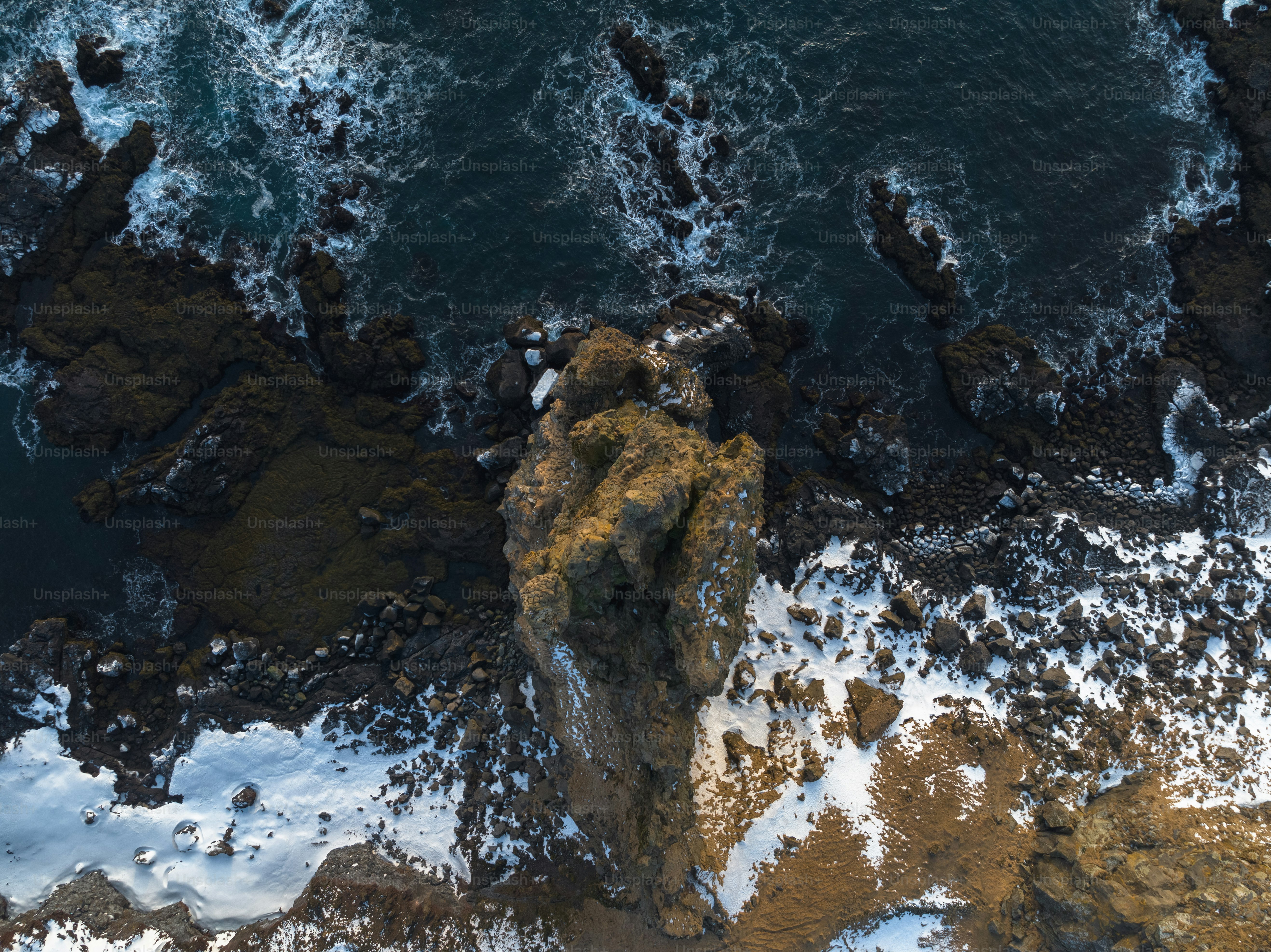 A bird's eye view of the ocean and rocks photo – Screensaver Image on ...