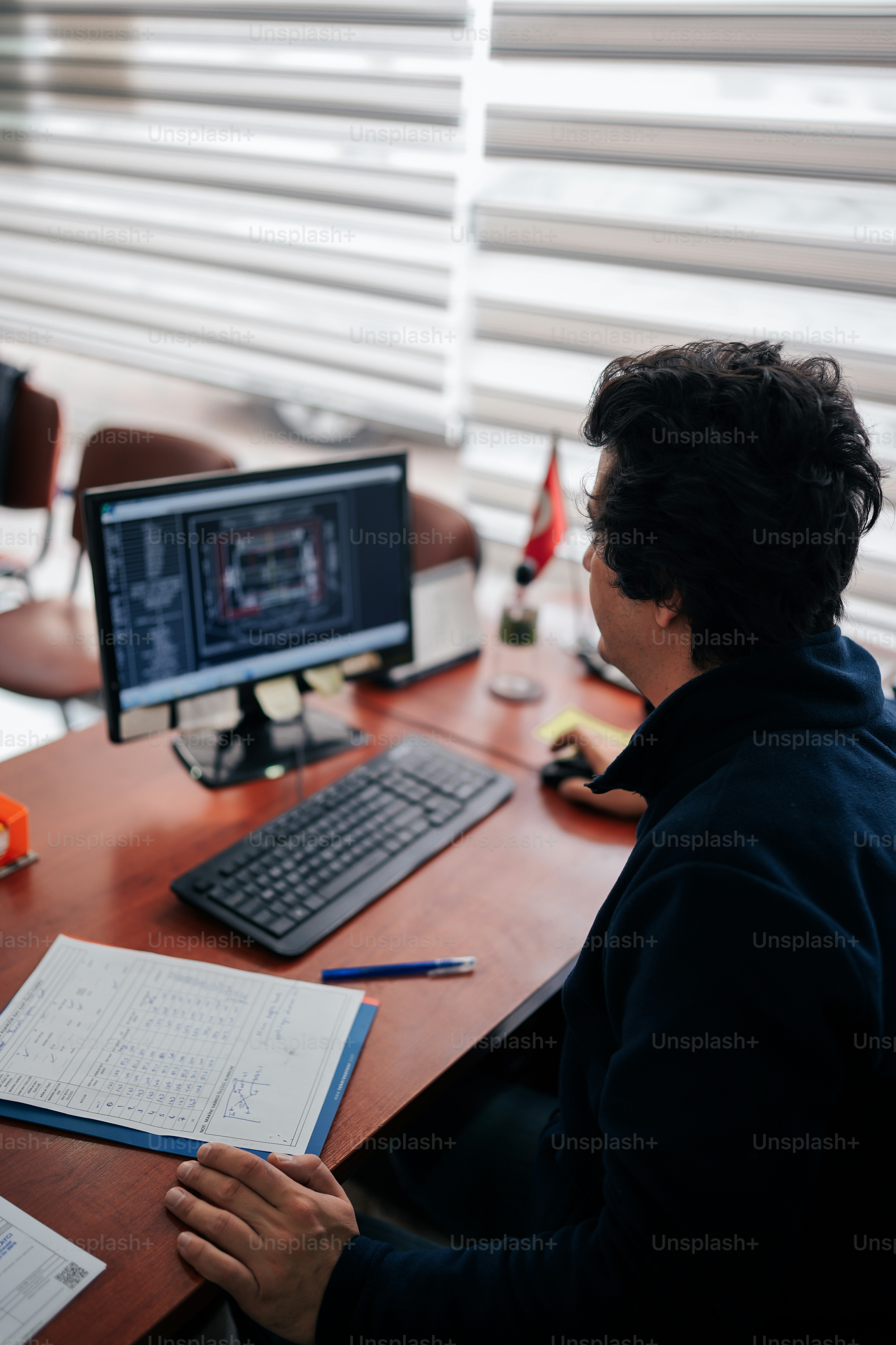 A person sitting at a desk with a computer photo – Professional Image ...