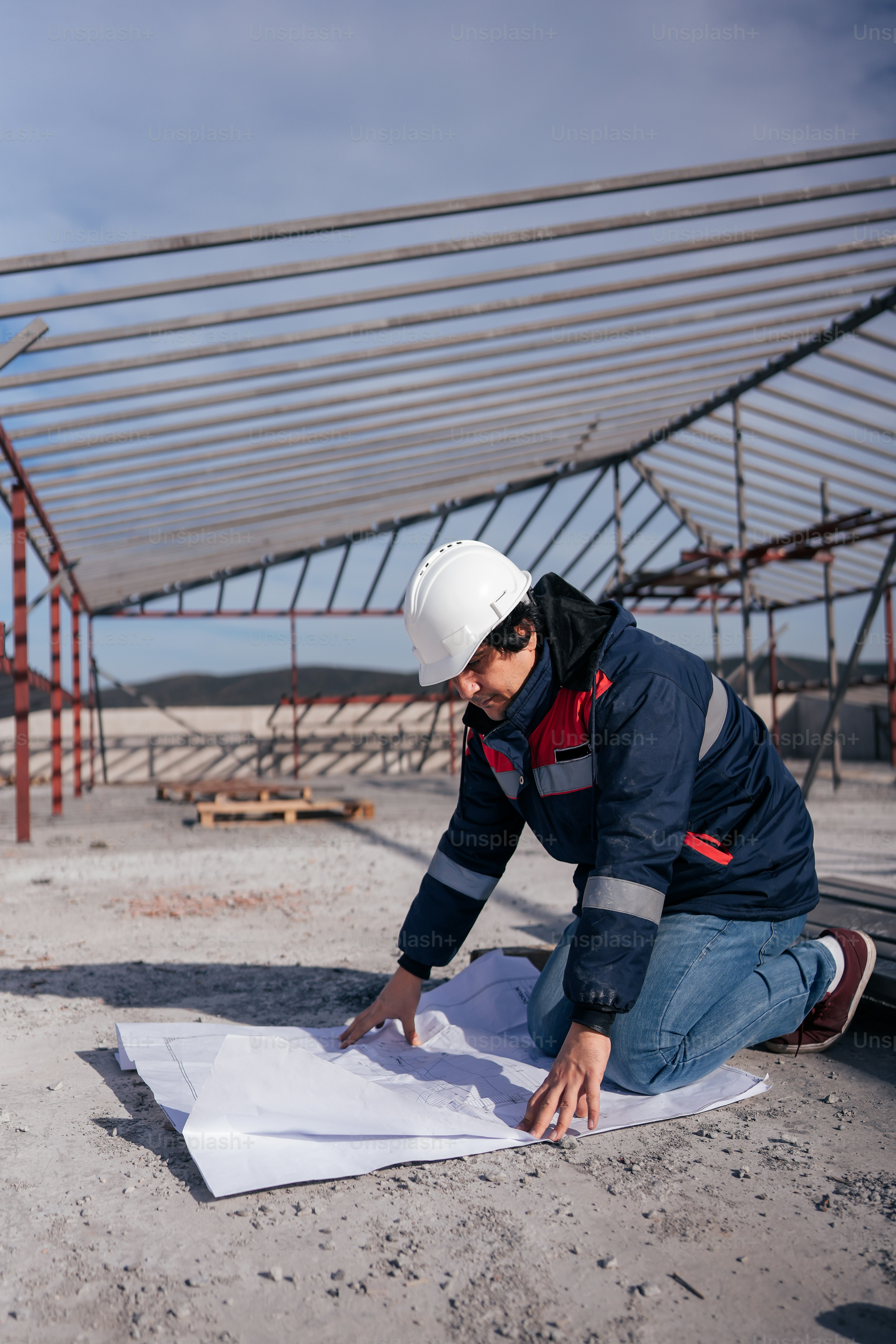 A man in a hard hat and hardhat working on a piece of paper photo ...
