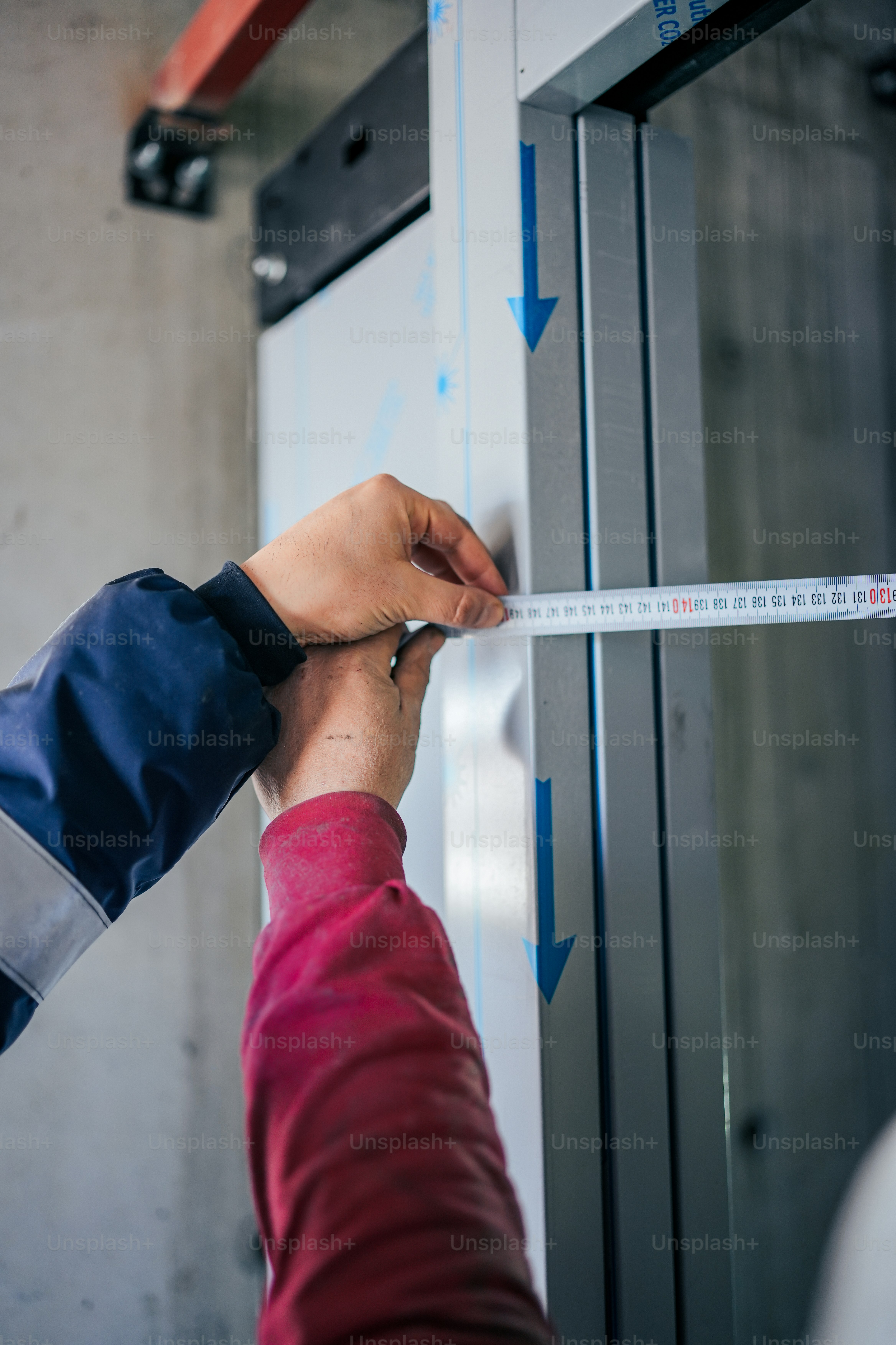 A person measuring the height of a metal cabinet photo – Worker Image ...