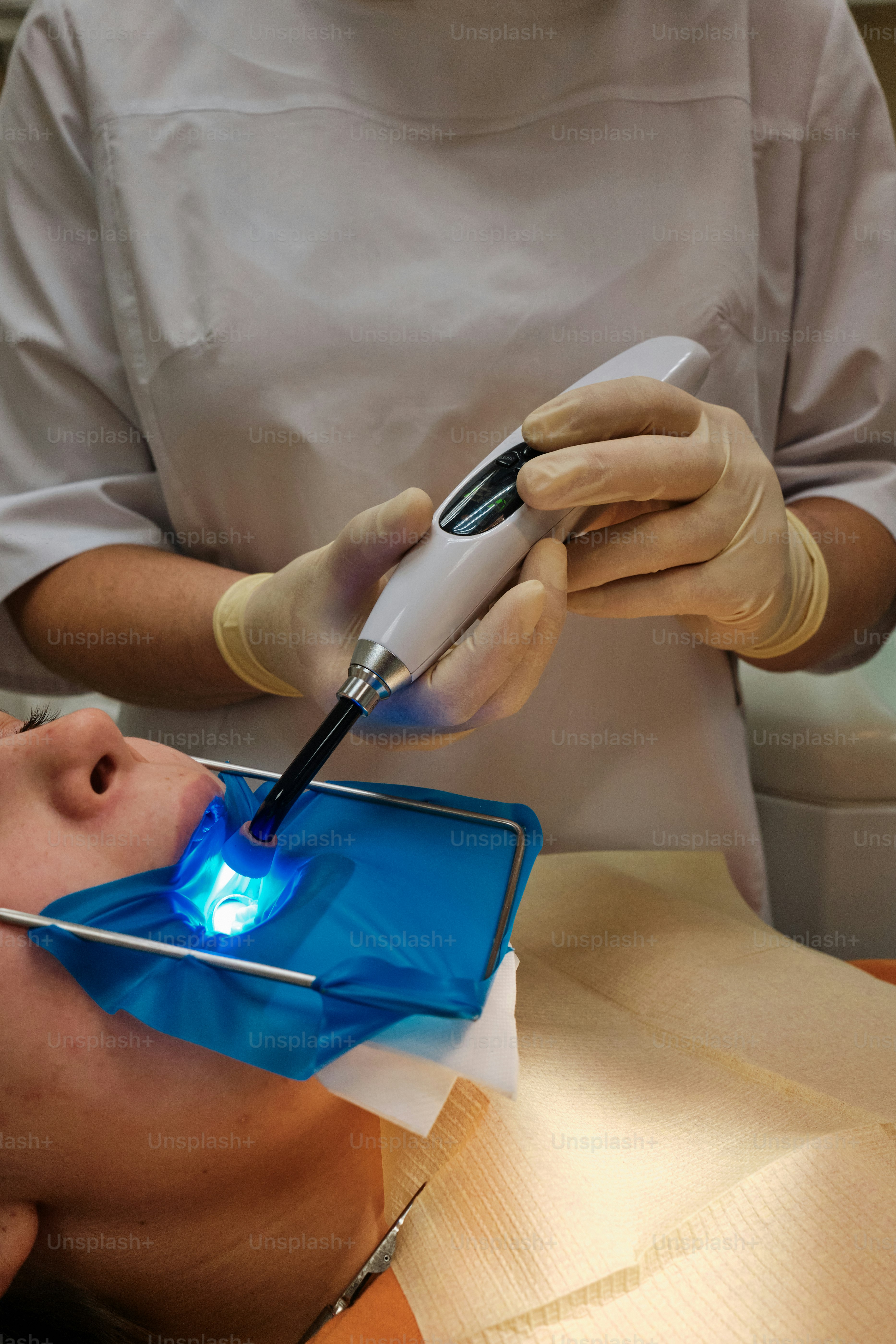 A person in a dentist's chair with a light on photo – Dentist Image on ...