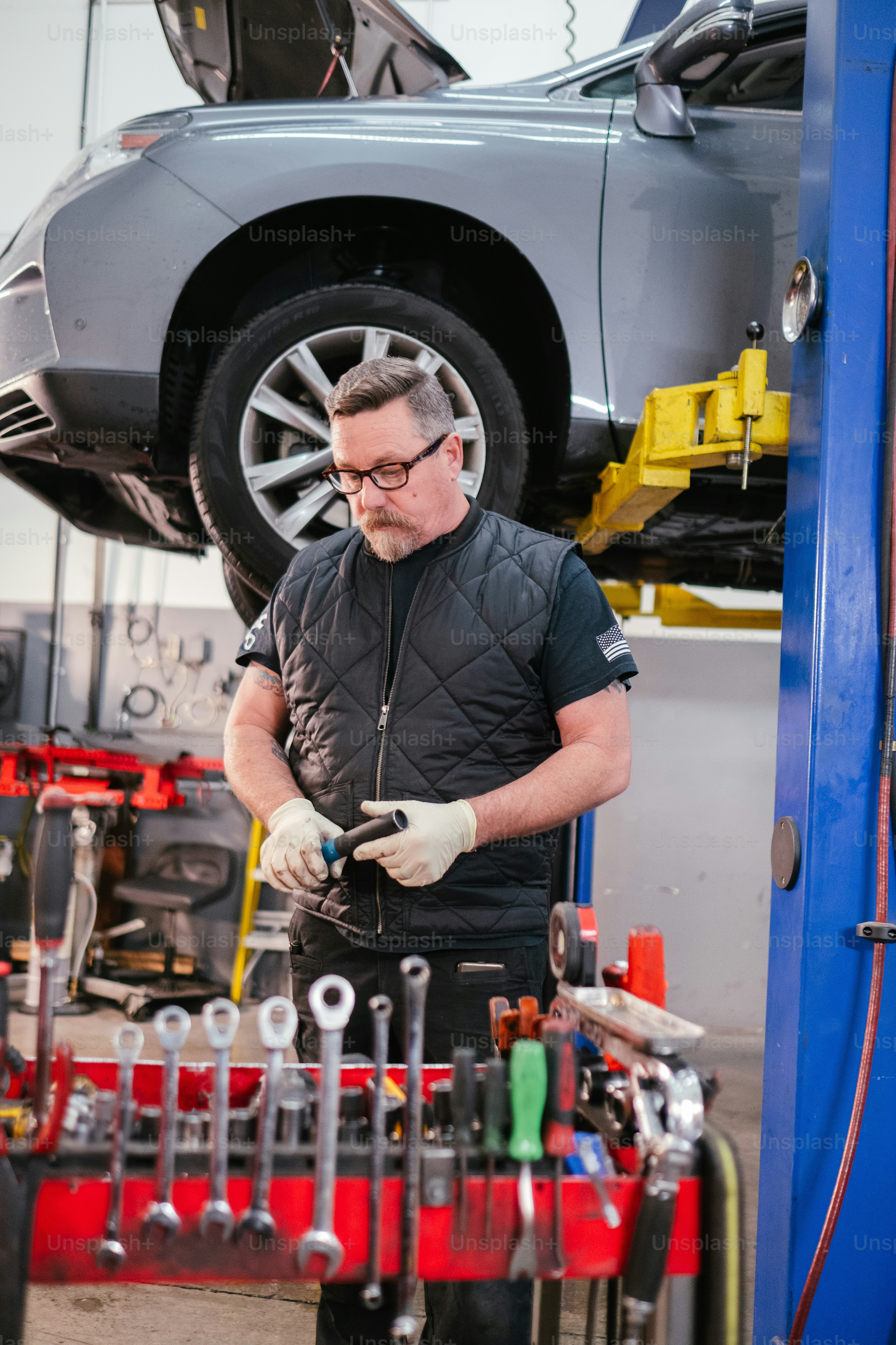A man working on a car in a garage photo – Car mechanic Image on Unsplash