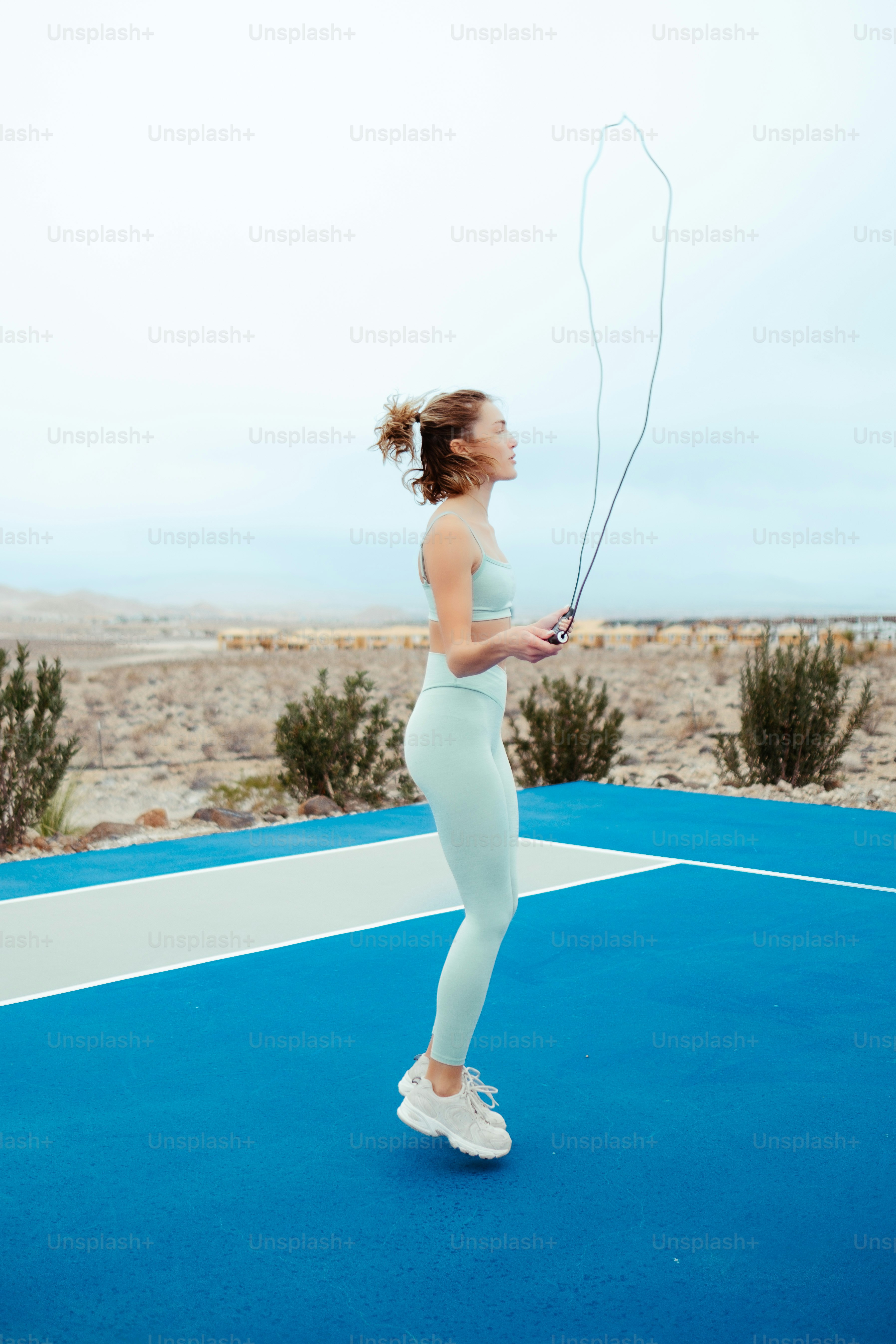A woman holding a tennis racquet on top of a tennis court photo – Jump ...