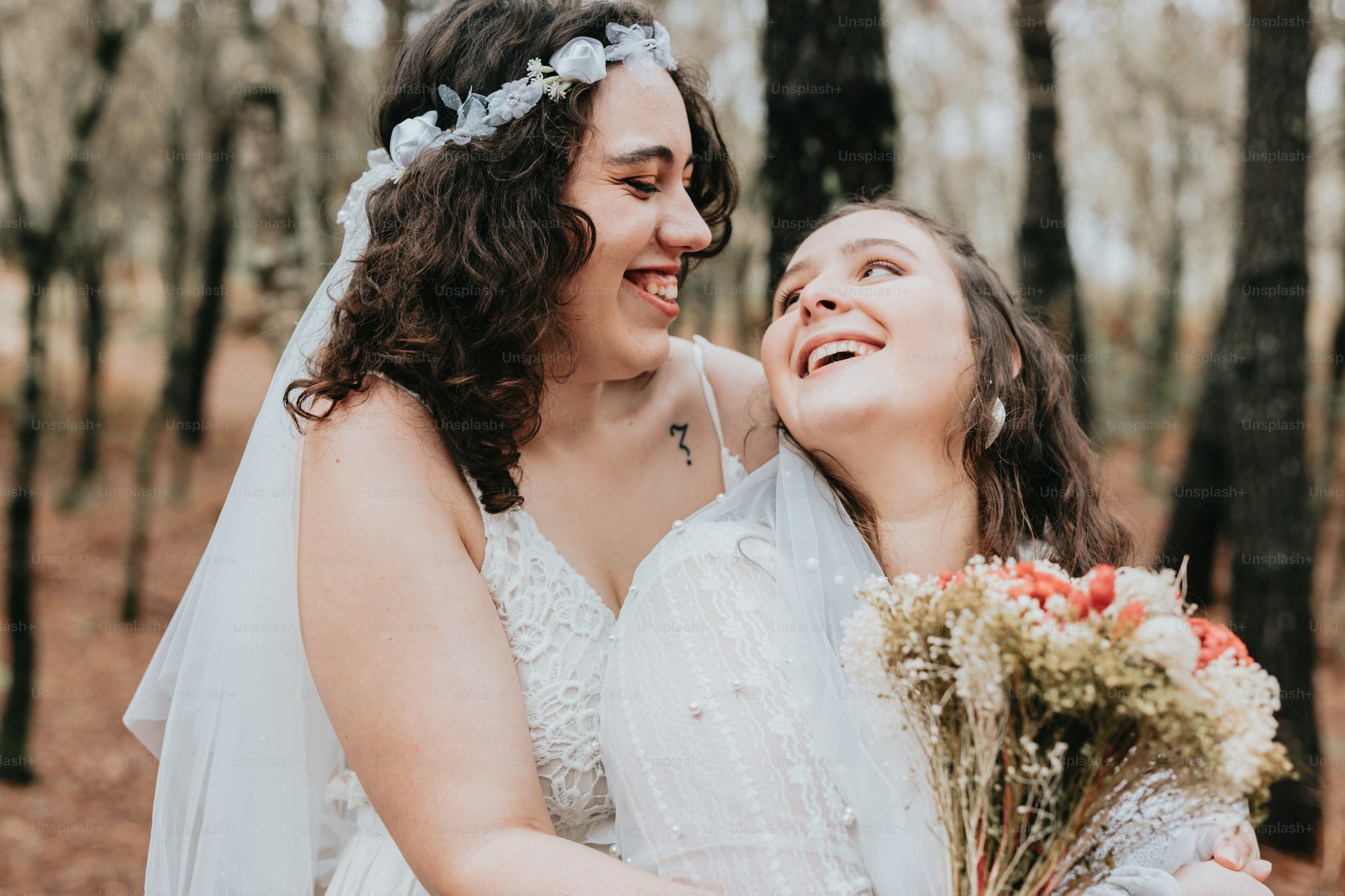 Two brides hugging each other in the woods photo – Getting married ...