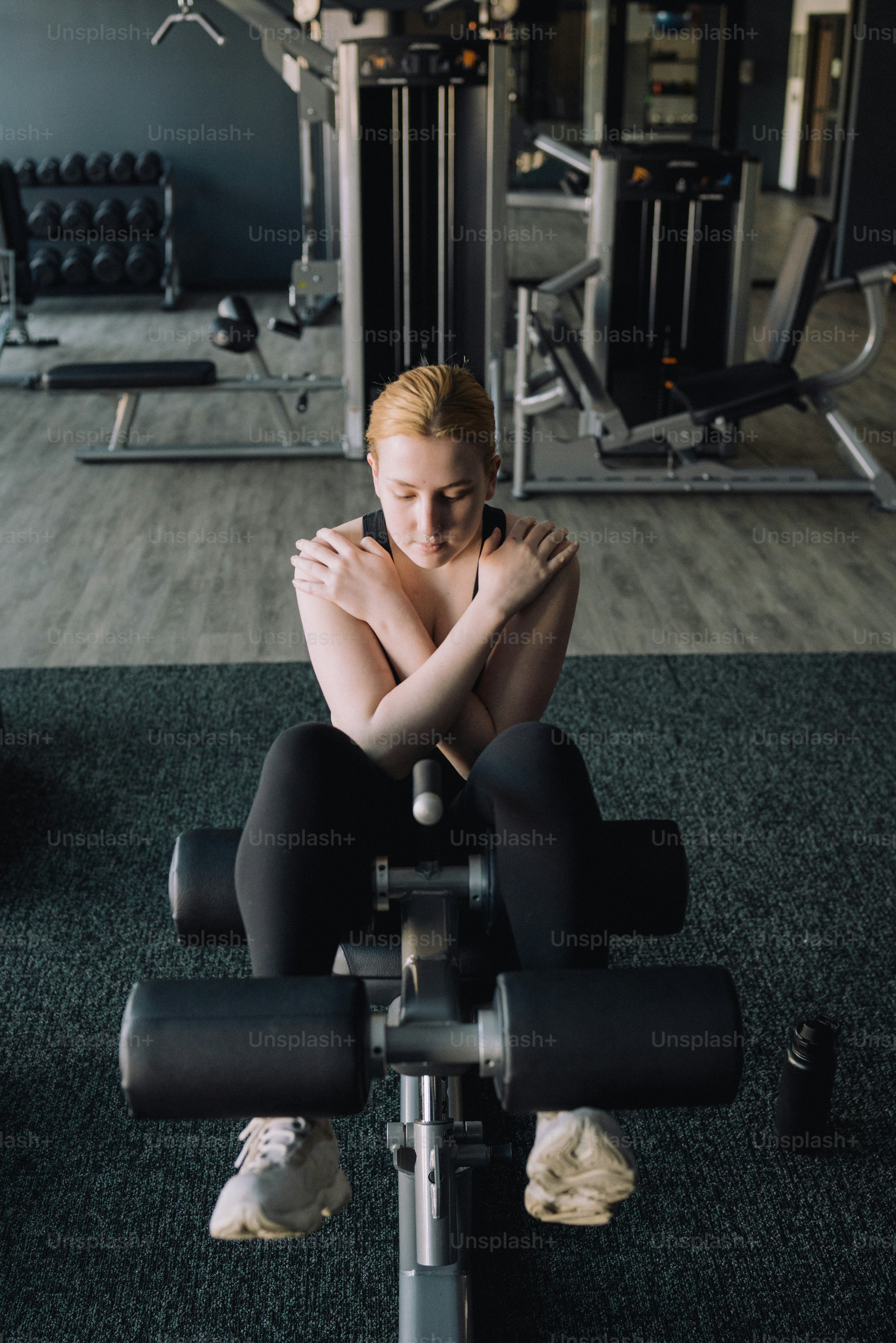 A woman sitting on a bench in a gym photo – Woman Image on Unsplash