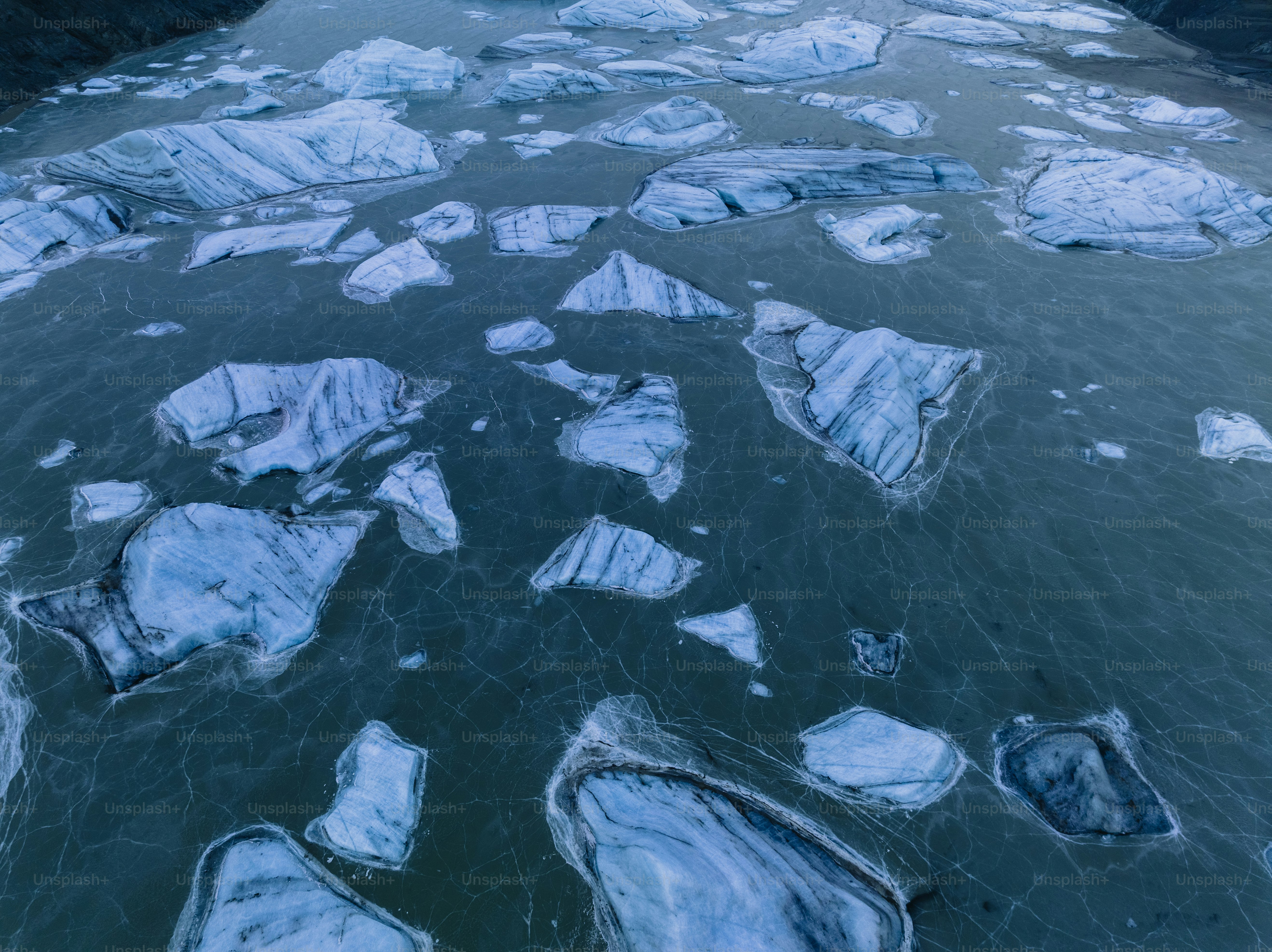 A group of ice chunks floating on top of a body of water photo ...