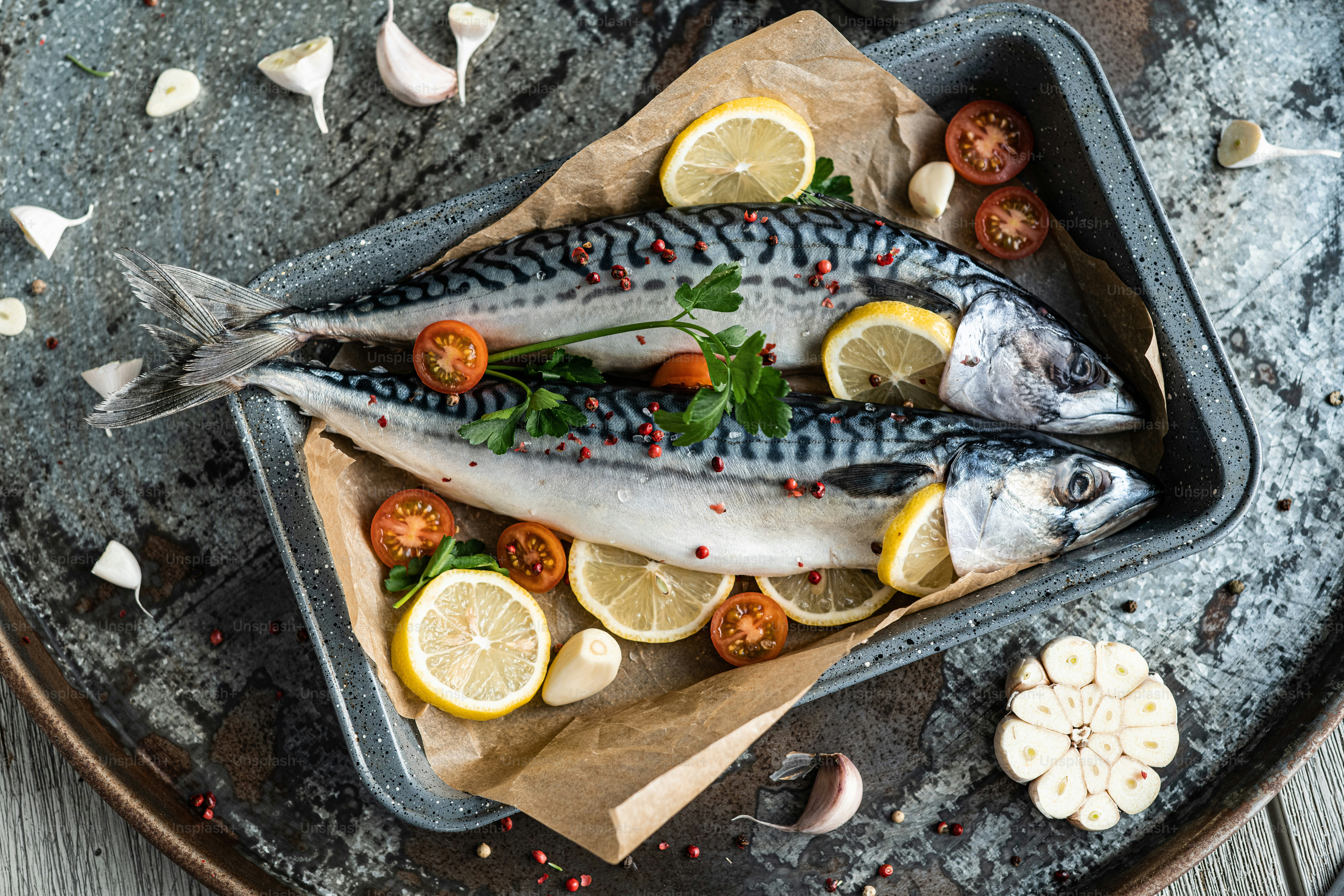 A couple of fish sitting on top of a pan photo – Fresh fish Image on ...