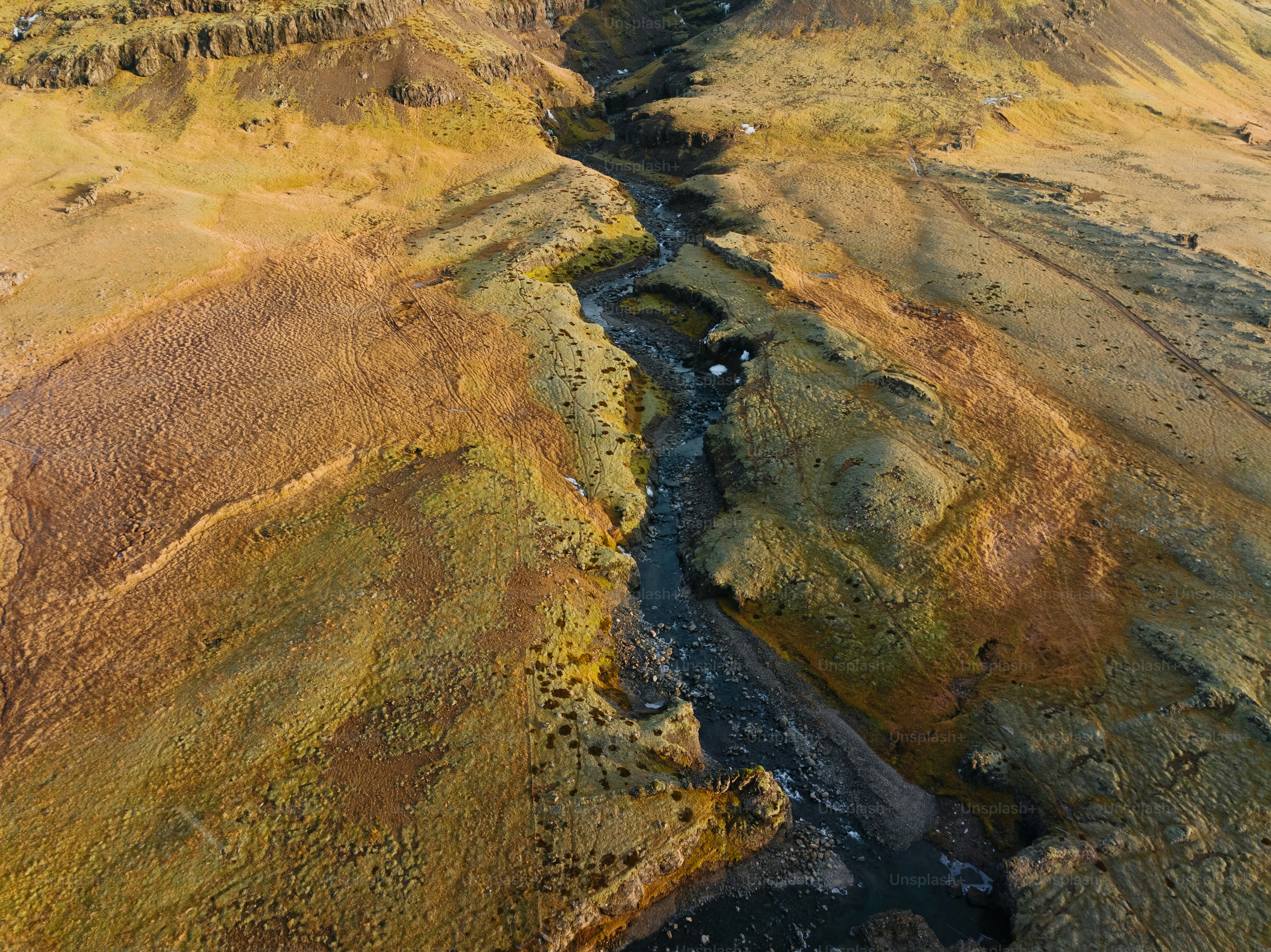 A bird's eye view of a river flowing through a valley photo – Riverbed ...