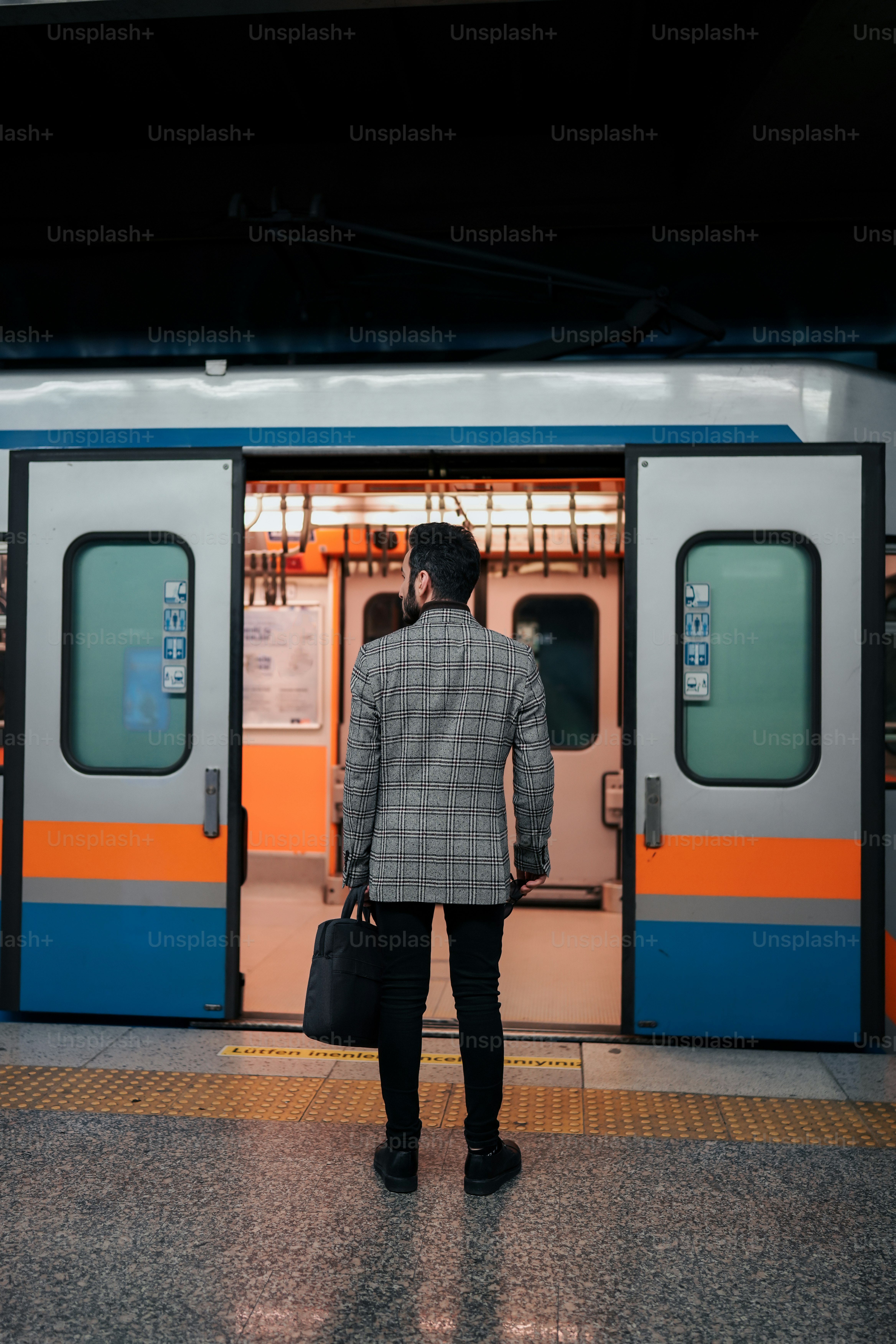 A man with a suitcase standing in front of a train photo – Male Image ...