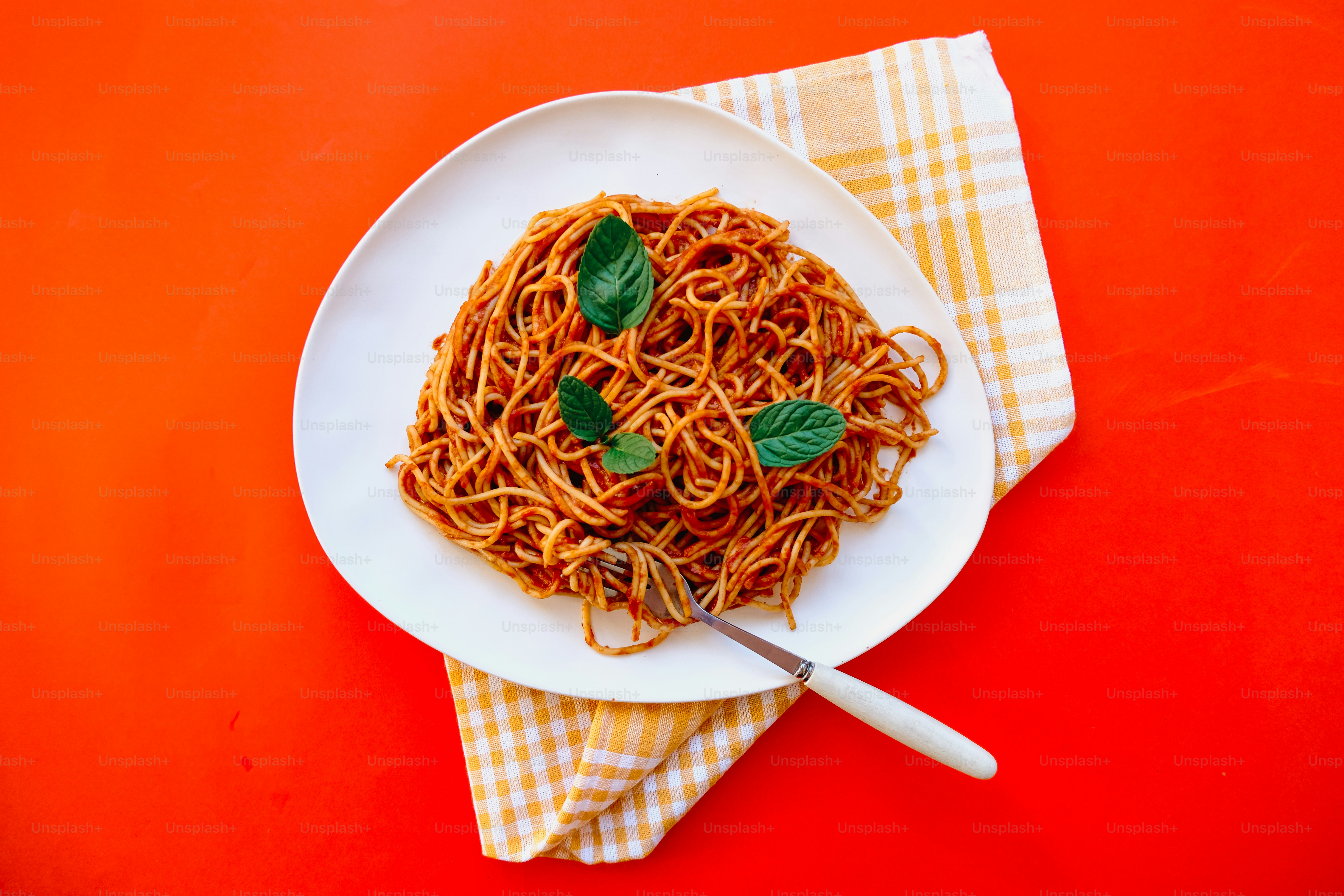 A plate of spaghetti with basil on top photo – Food Image on Unsplash