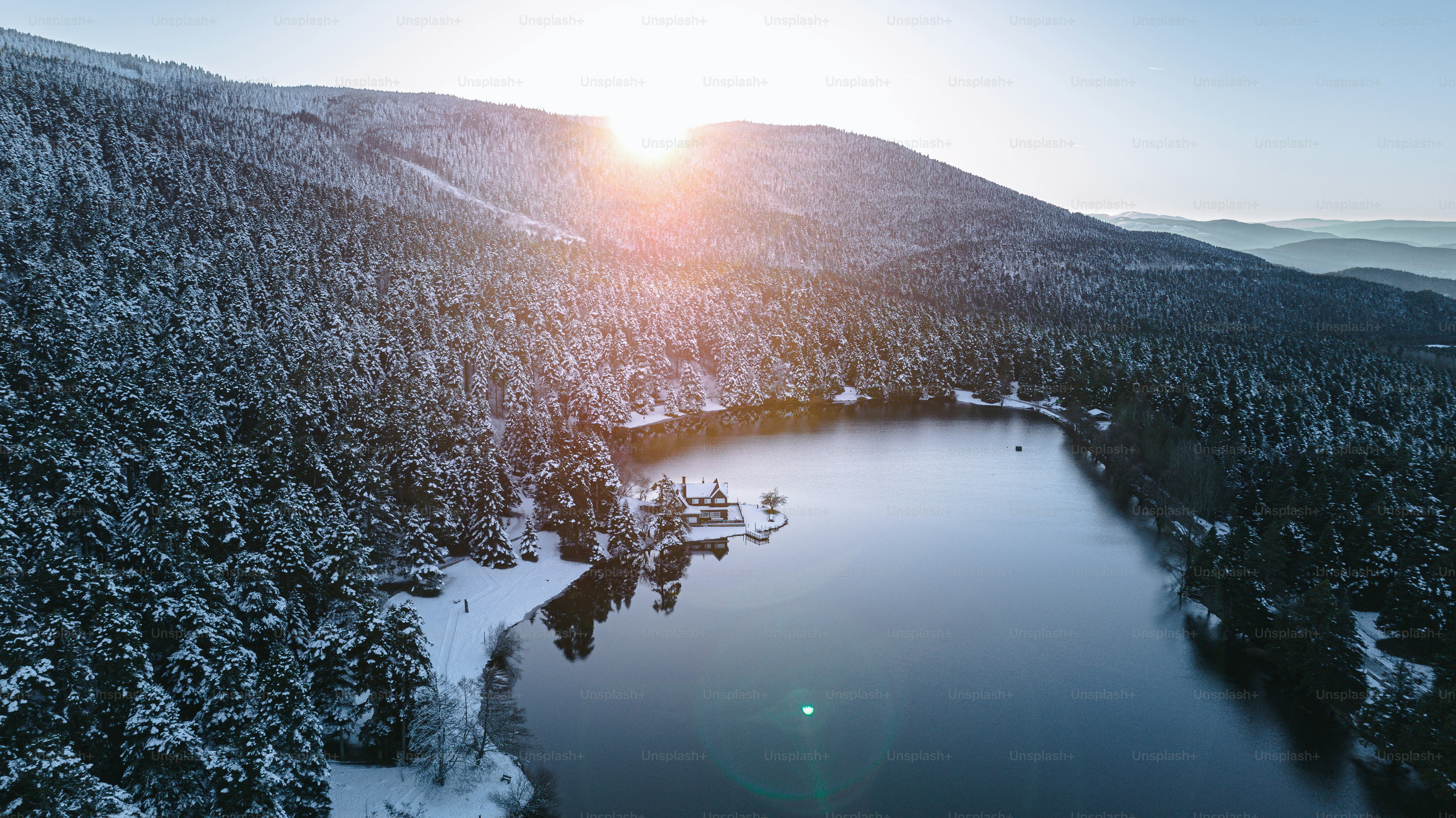 A large lake surrounded by snow covered mountains photo – Sunshine ...