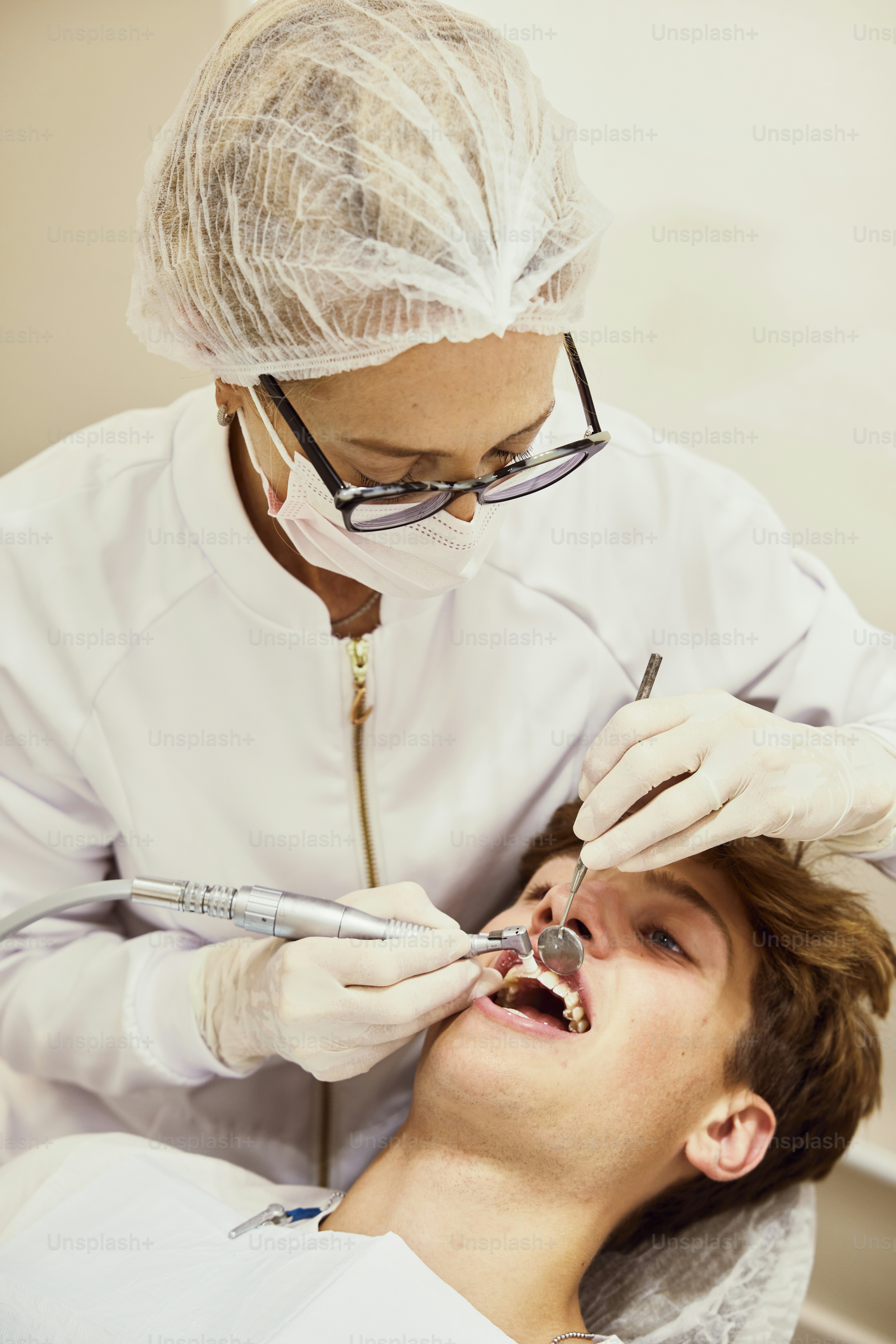 A man getting his teeth checked by a dentist photo – Tooth Image on ...