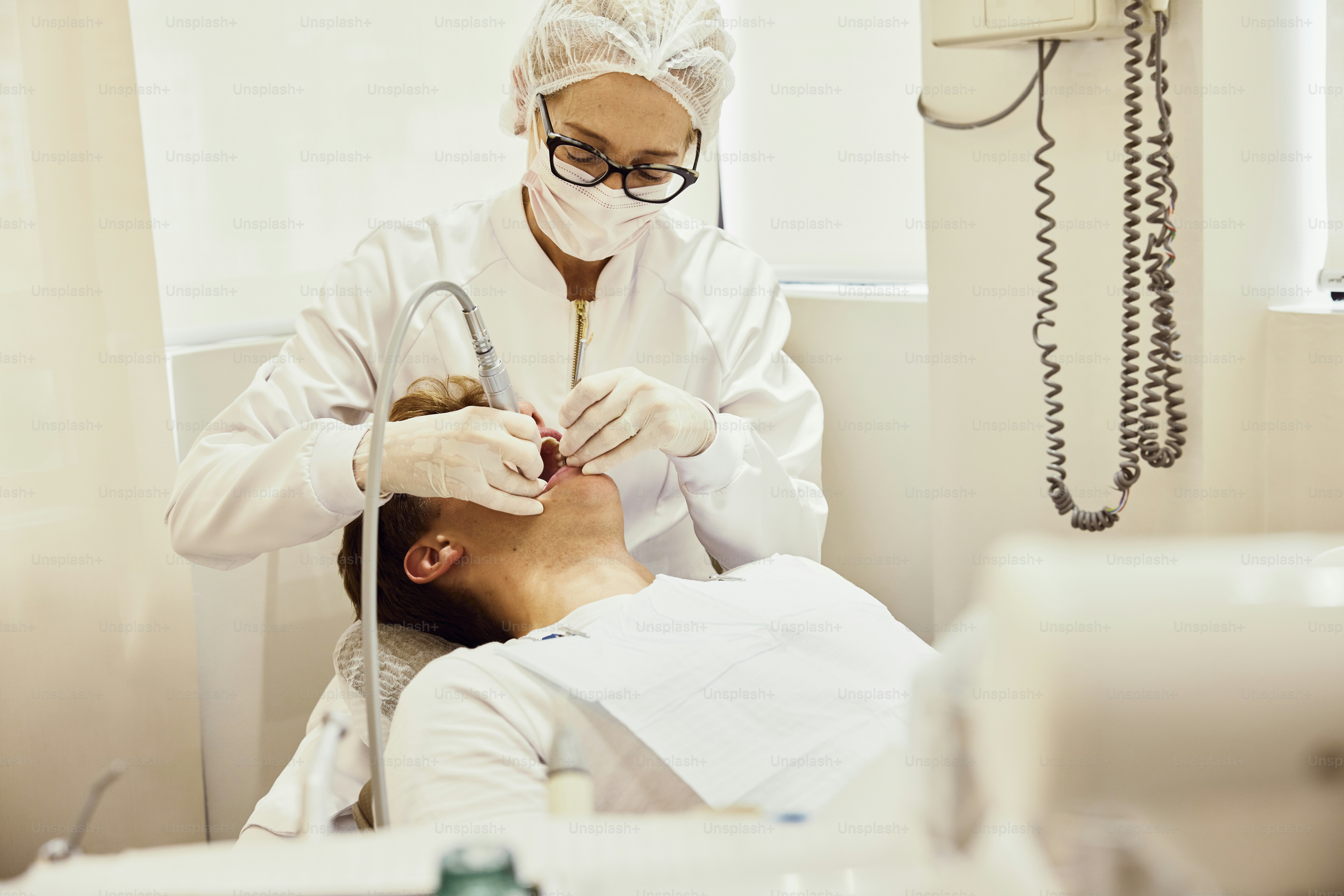 A man getting his teeth checked by a dentist photo – Tooth Image on ...