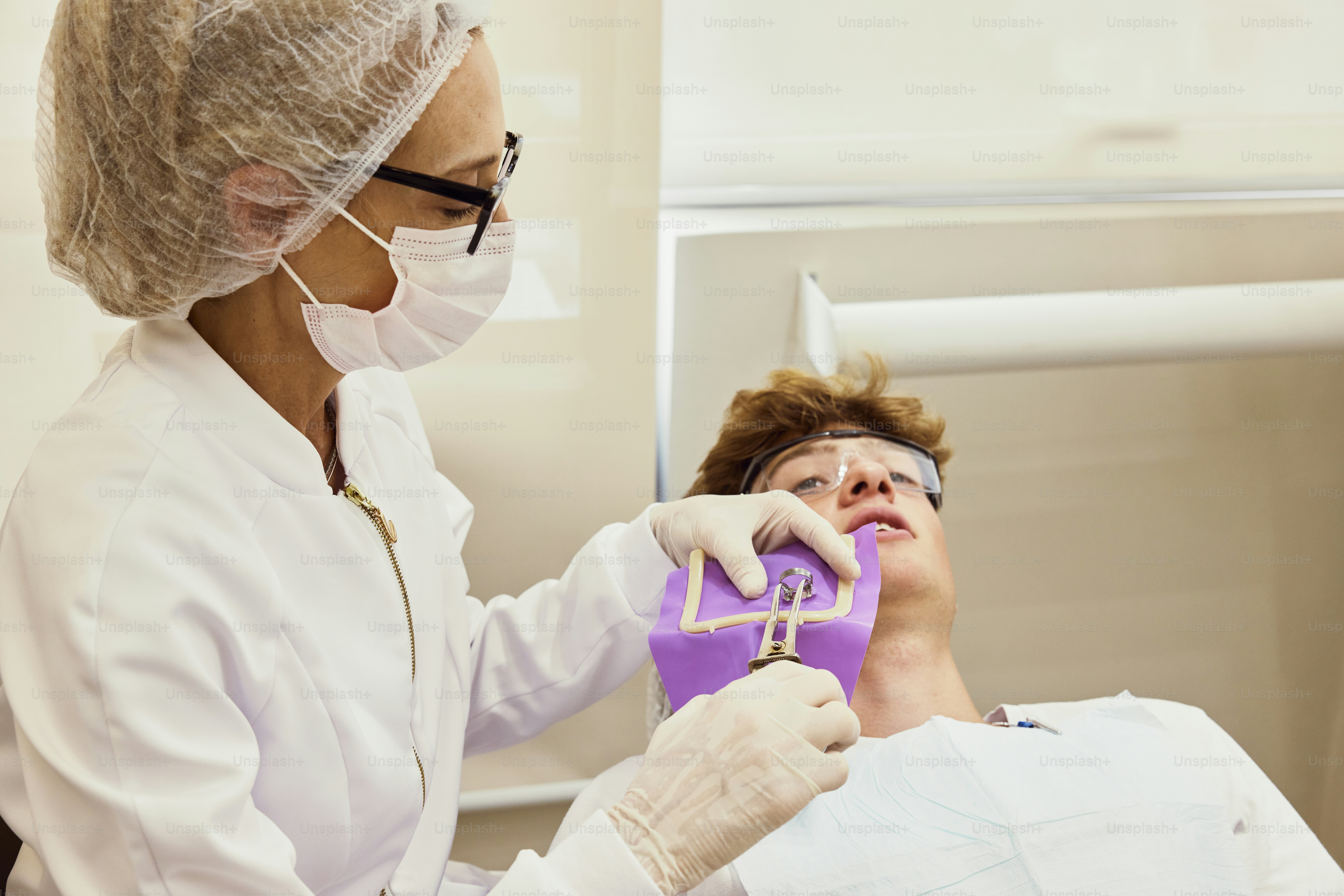 A woman getting her teeth checked by a dentist photo – Dentist Image on ...