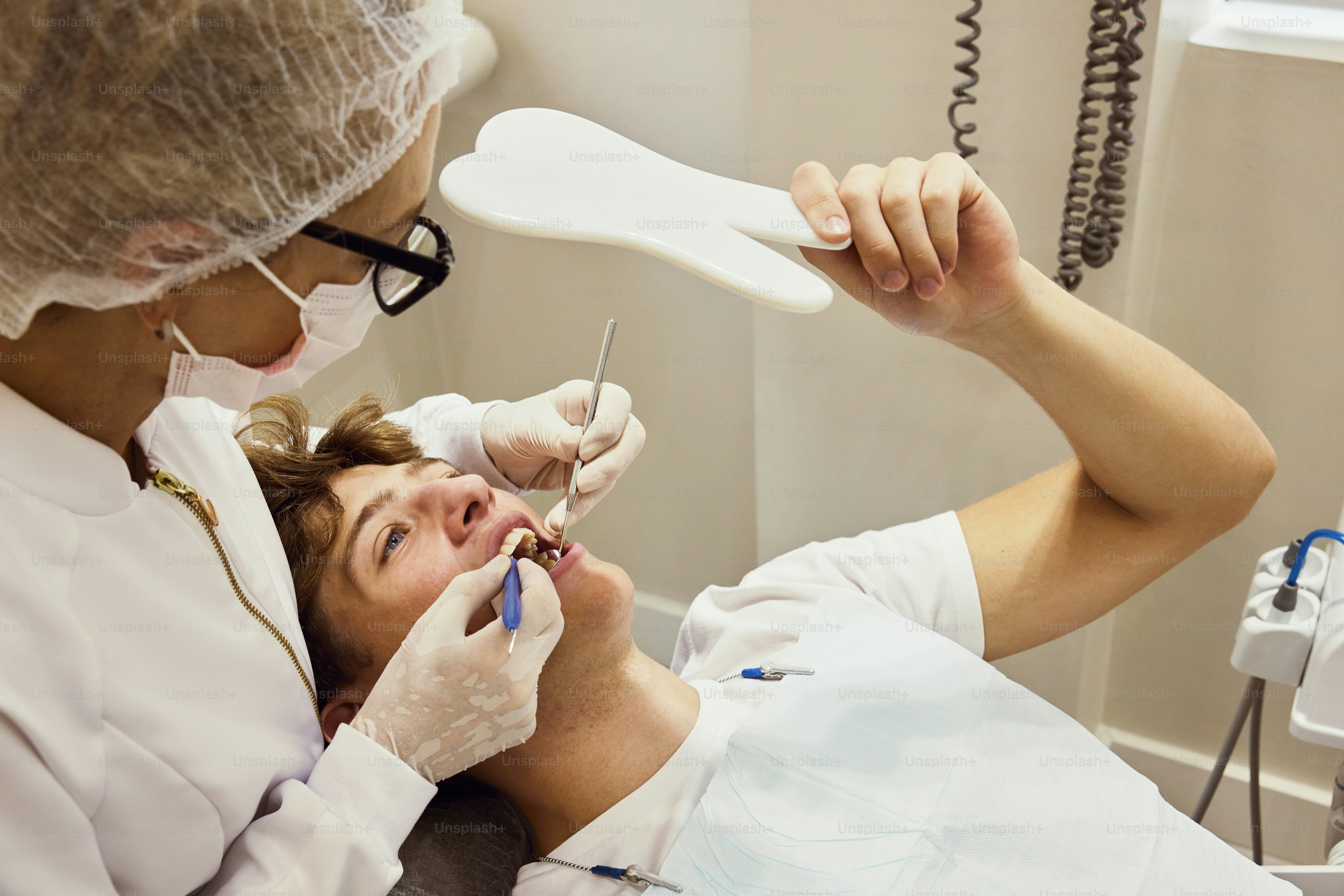 A woman getting her teeth checked by a dentist photo – Odontology Image ...