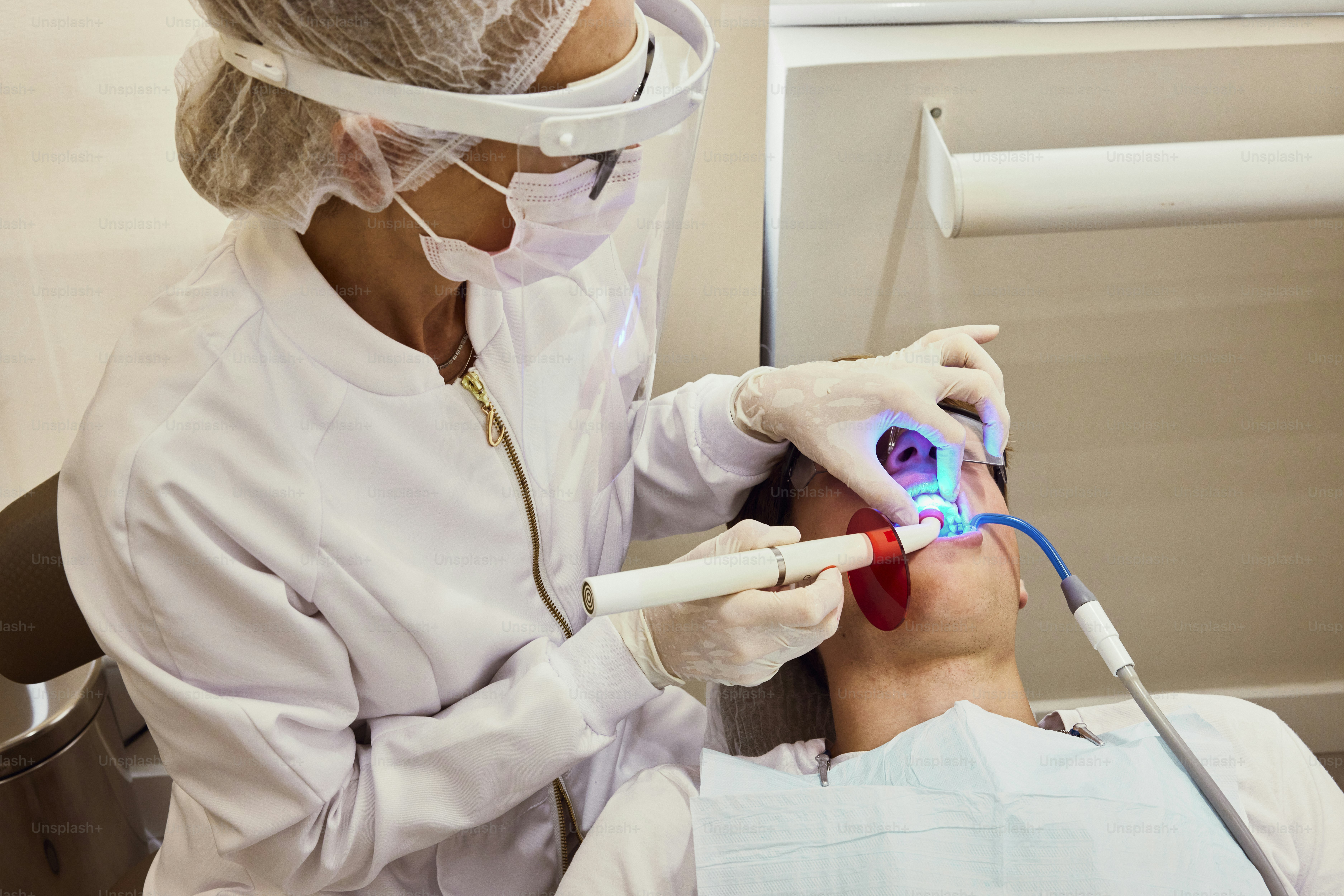 A woman getting her teeth checked by a dentist photo – Dentist Image on ...