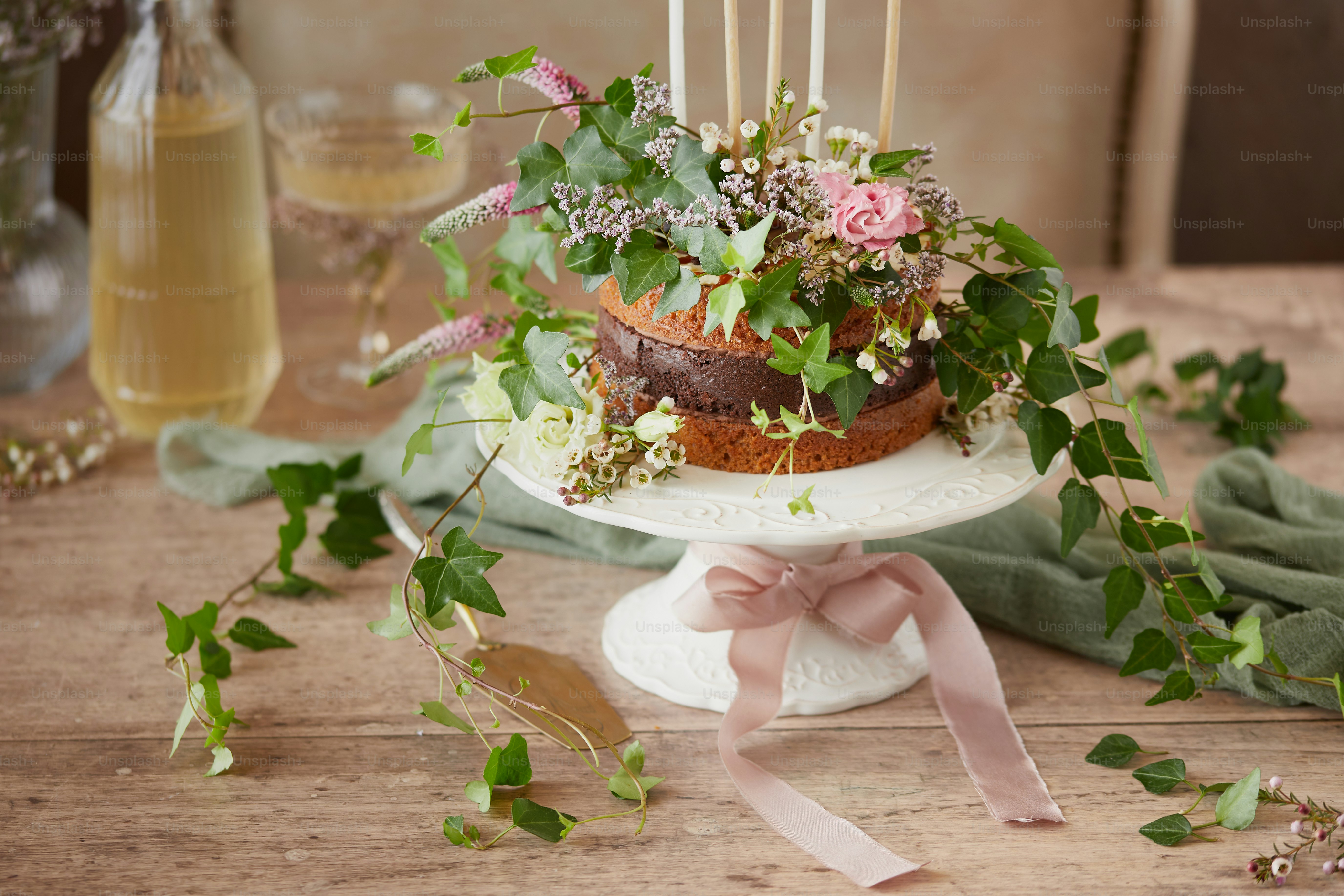 A cake sitting on top of a white cake plate photo – Wedding flowers ...