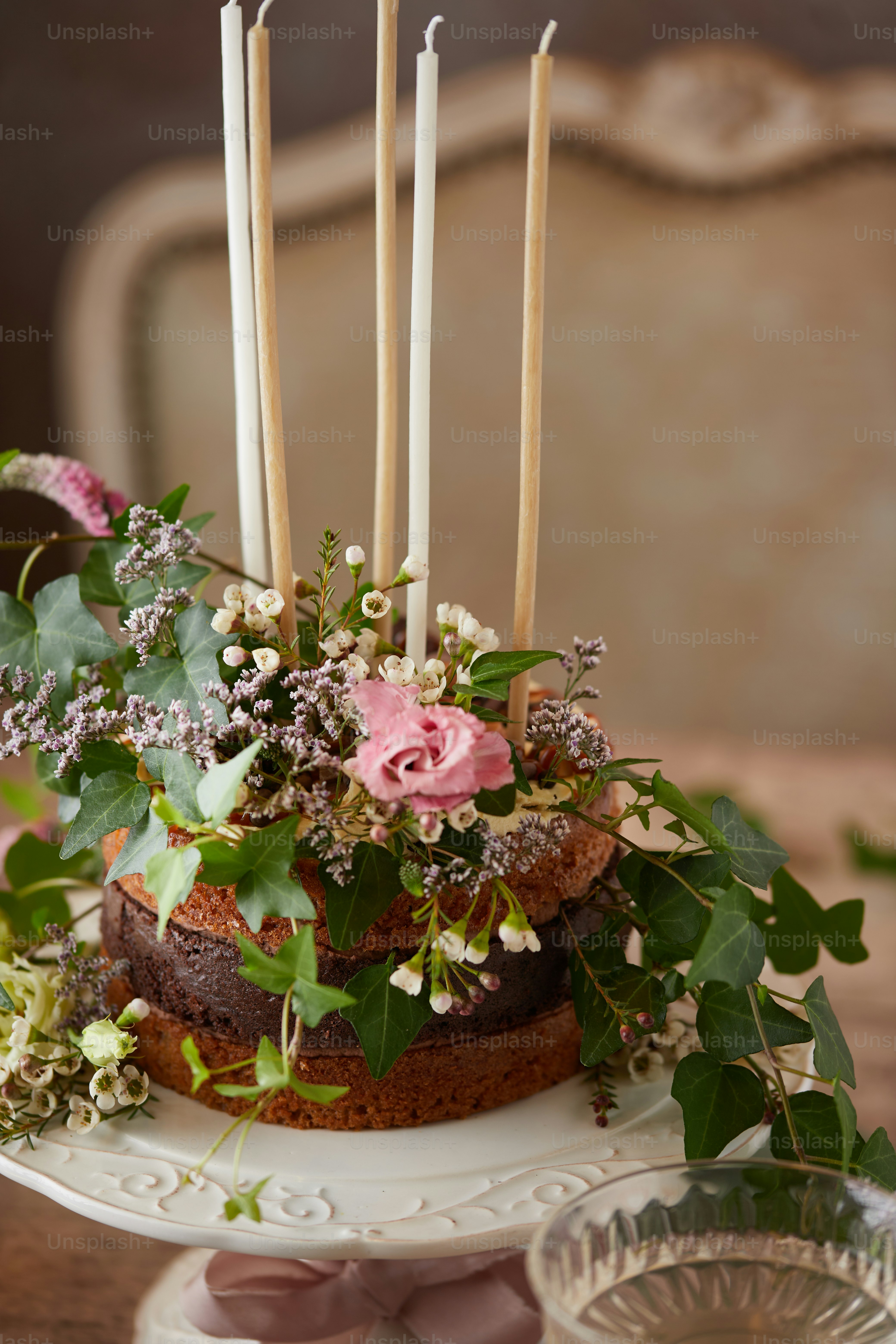 A cake sitting on top of a white cake plate photo – Wedding flowers ...
