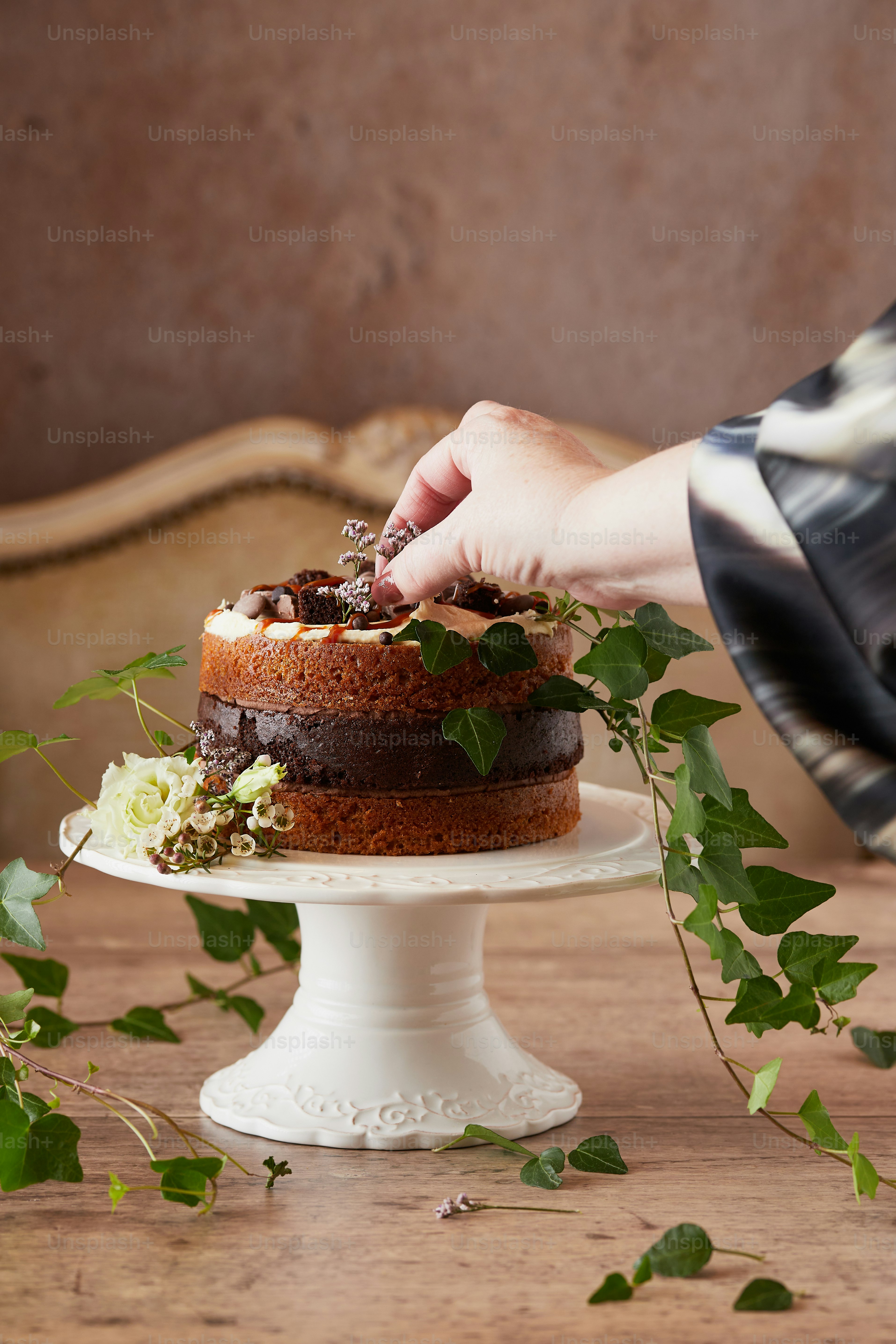 A person decorating a cake with greenery photo – Wedding Image on Unsplash