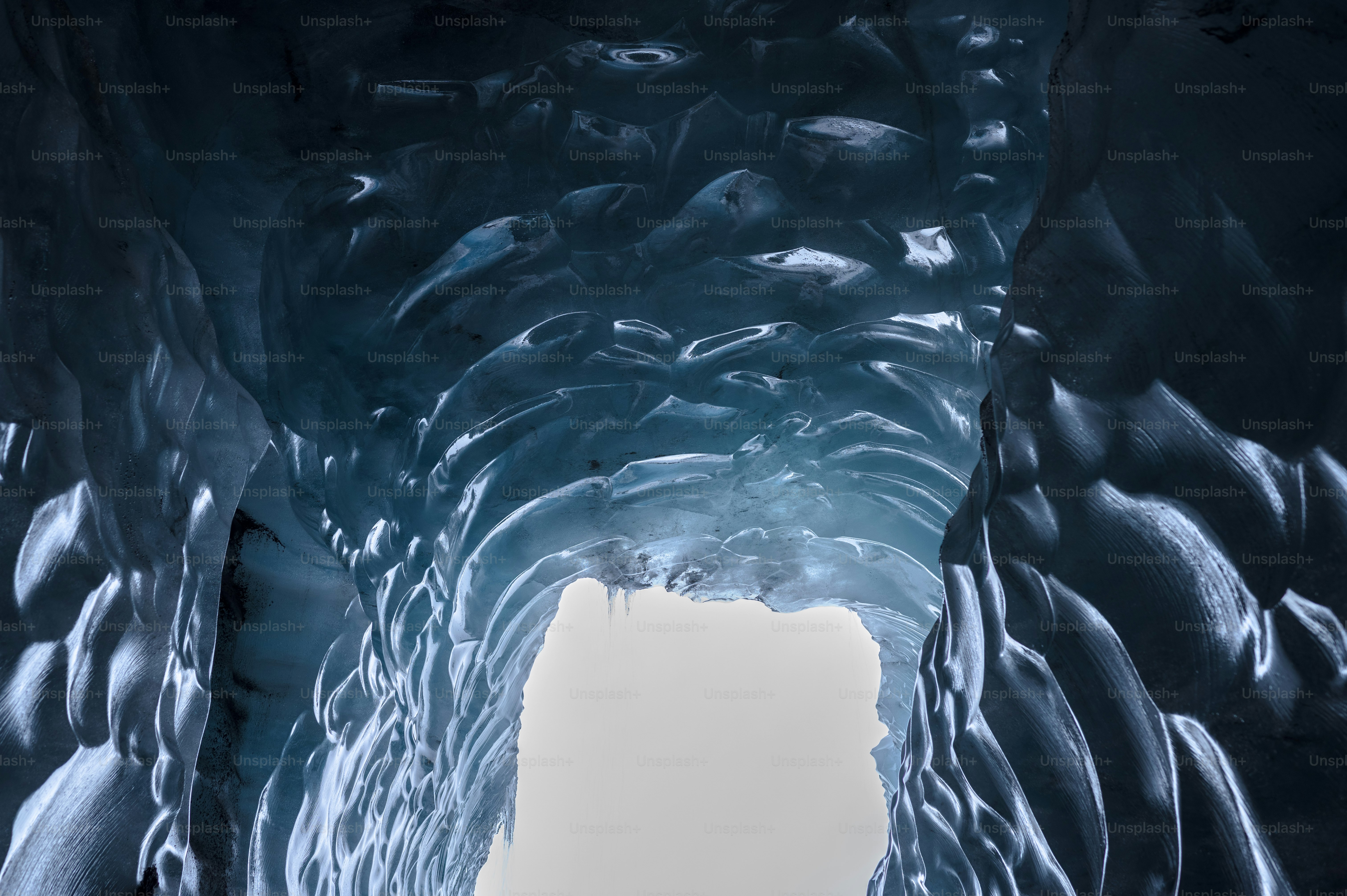 A large ice cave with water flowing down it photo – Caves Image on Unsplash