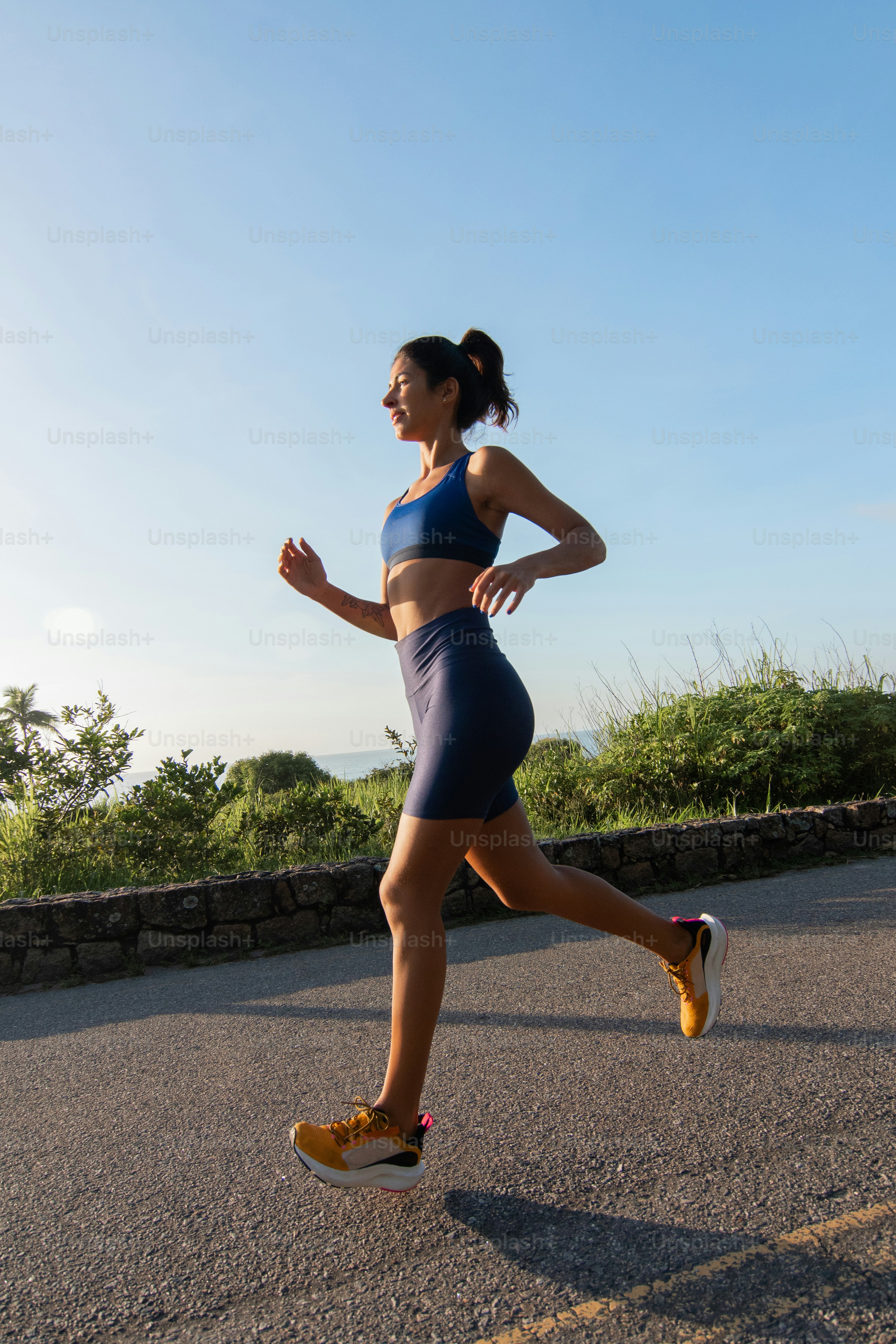 A woman running down a road with a sky background photo – Motivated ...