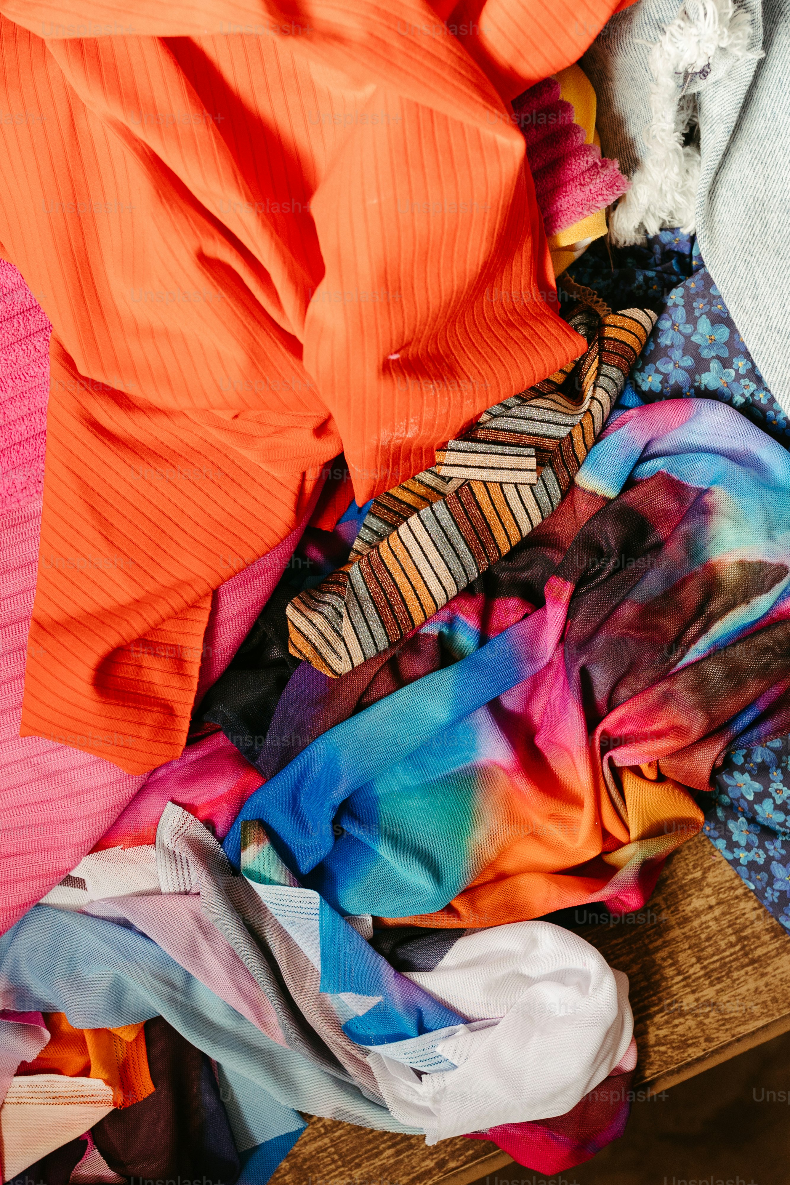 Foto Un montón de ropa sentada encima de una mesa de madera – Material ...