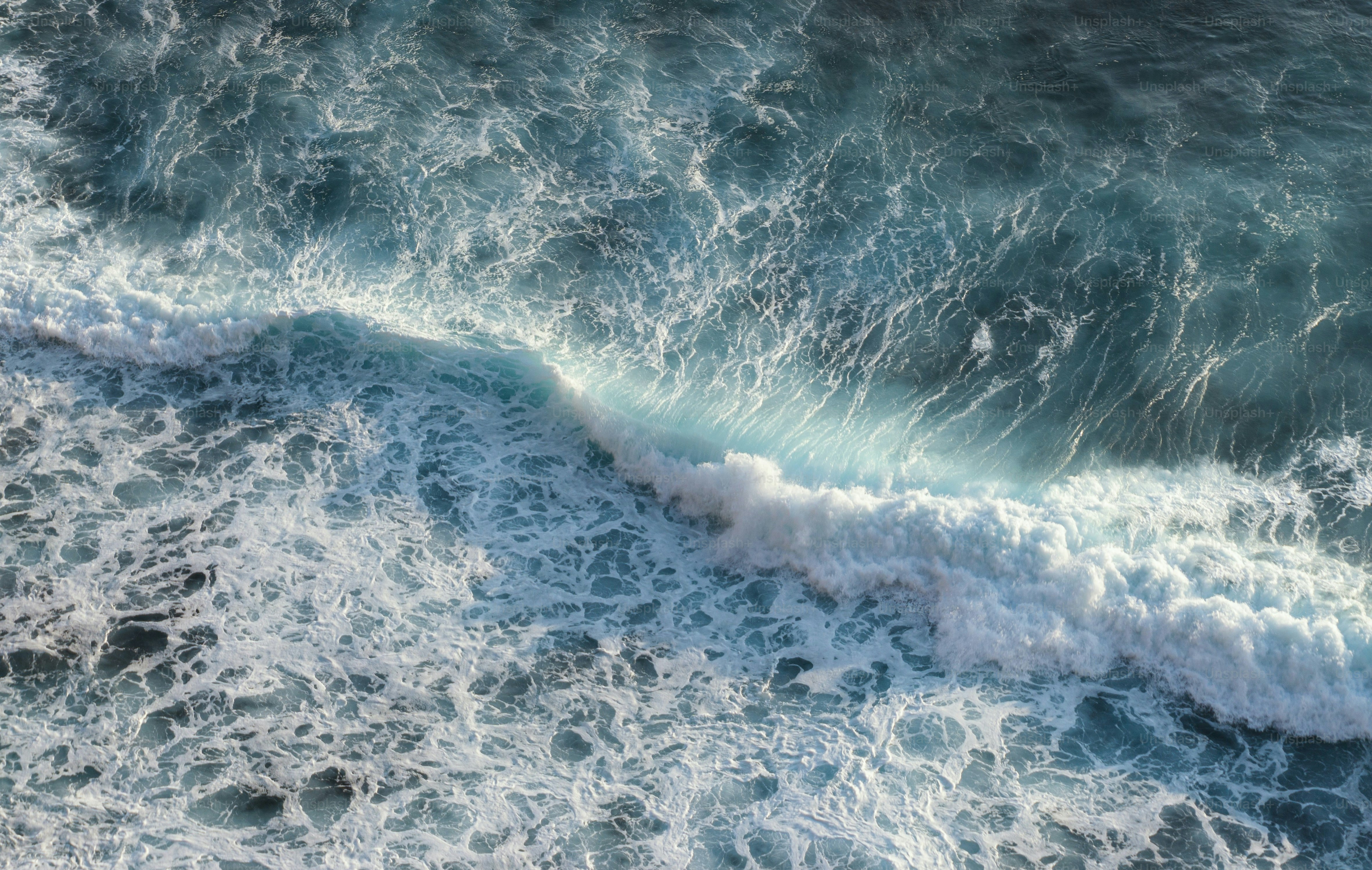 A large body of water with waves coming in photo – Texture Image on ...