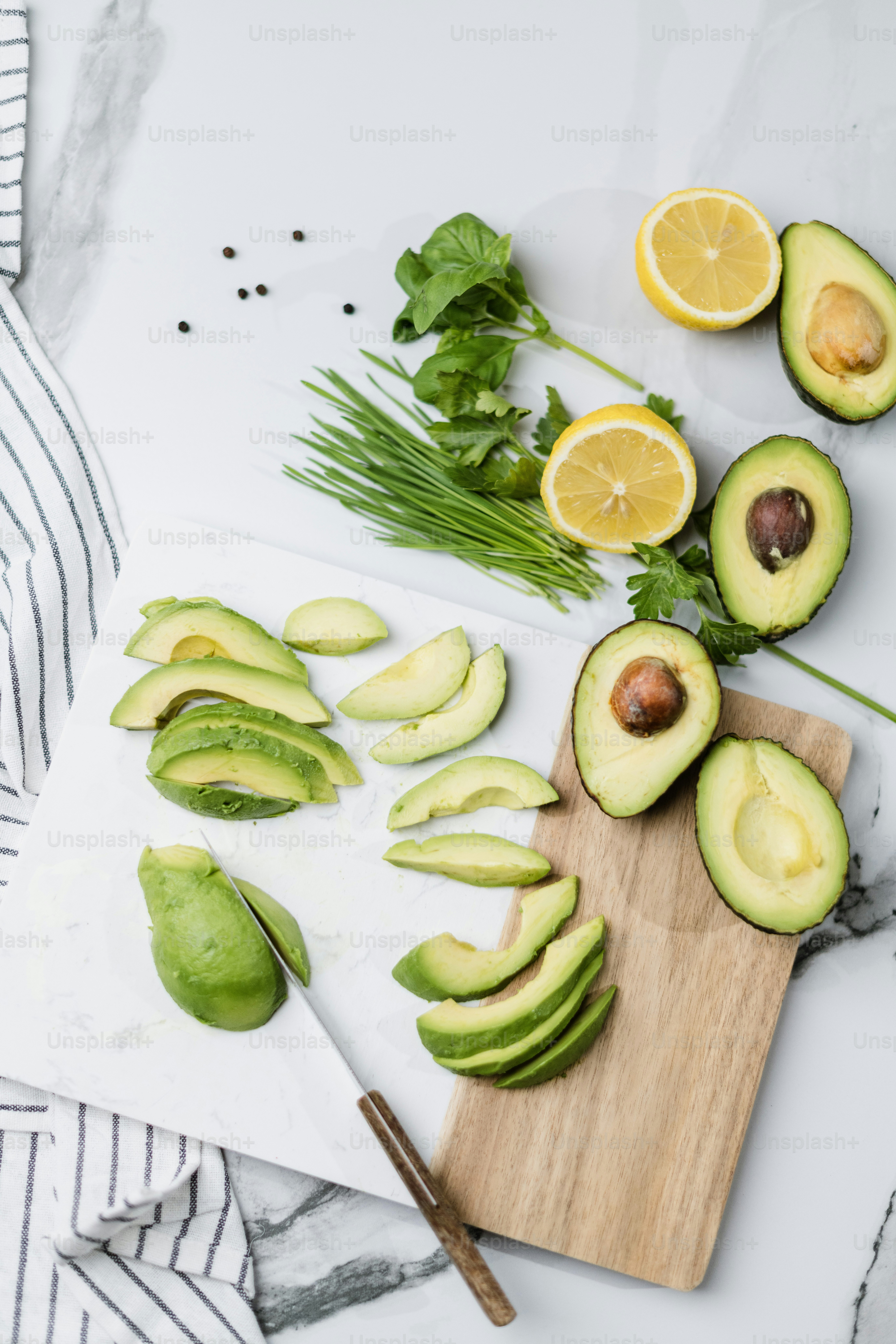 A cutting board topped with sliced avocados and lemons photo – Food ...