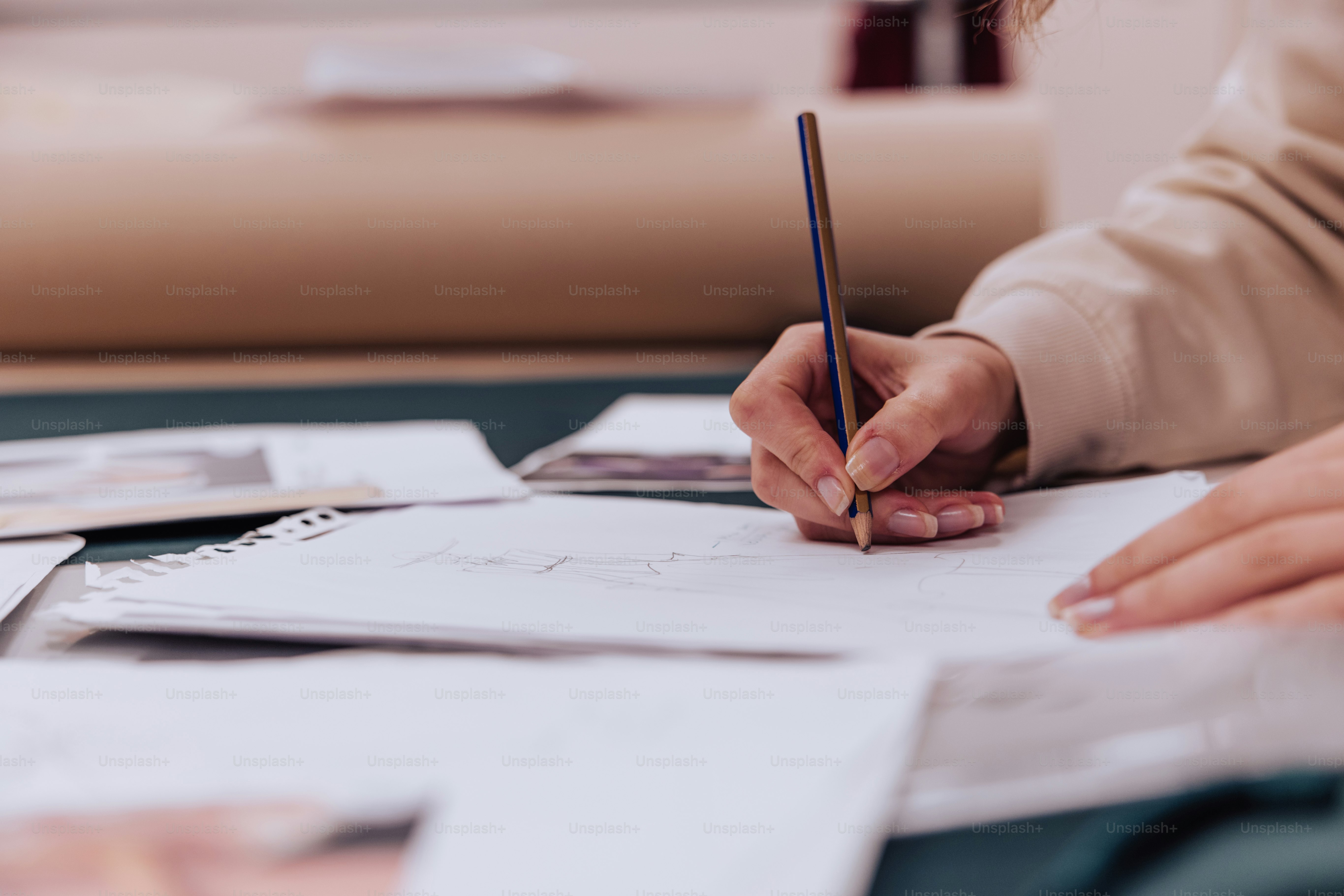 A person writing on a piece of paper with a pencil photo – Drawing ...