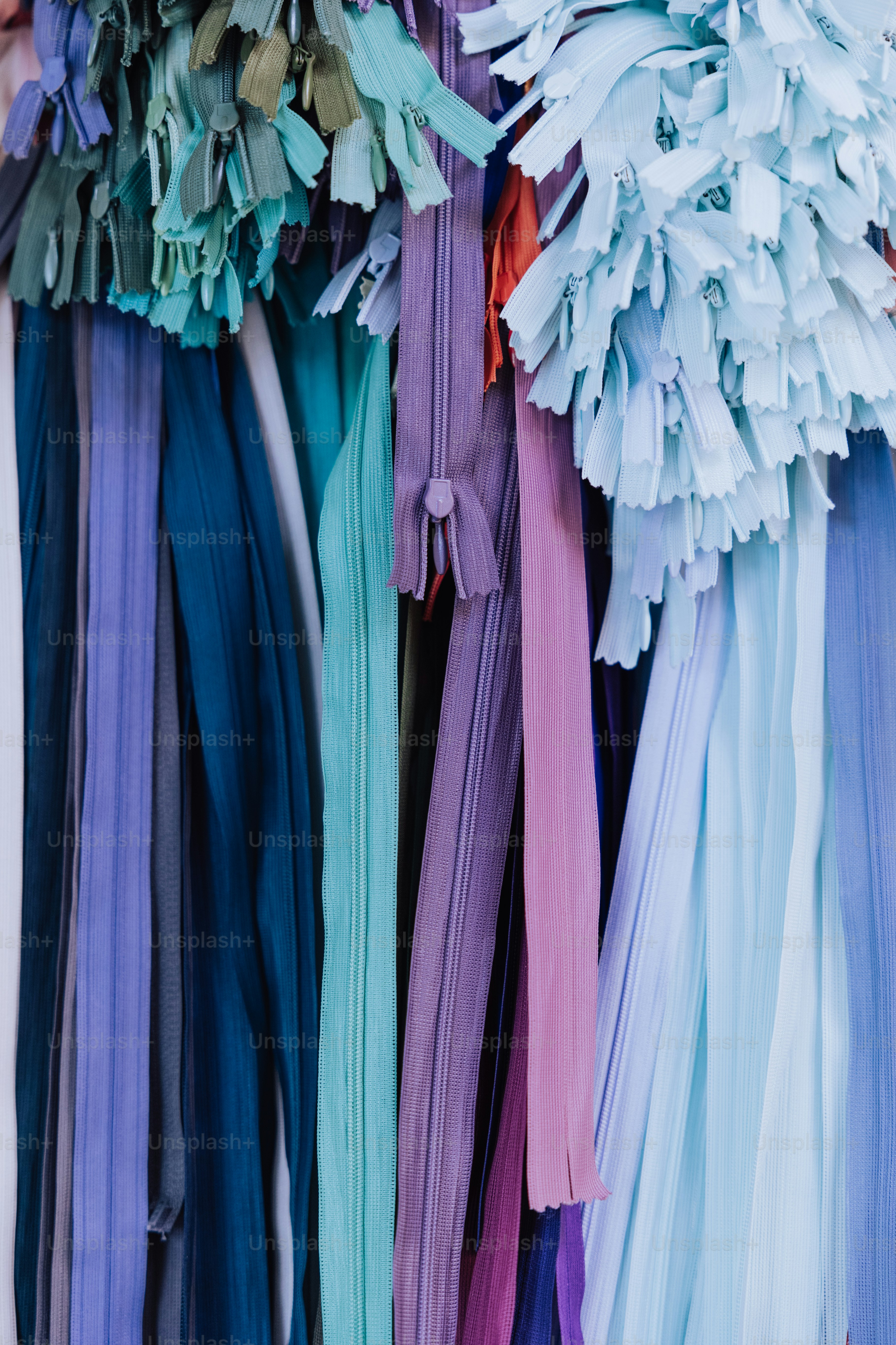 A bunch of different colored ribbons hanging on a wall photo – Fashion ...