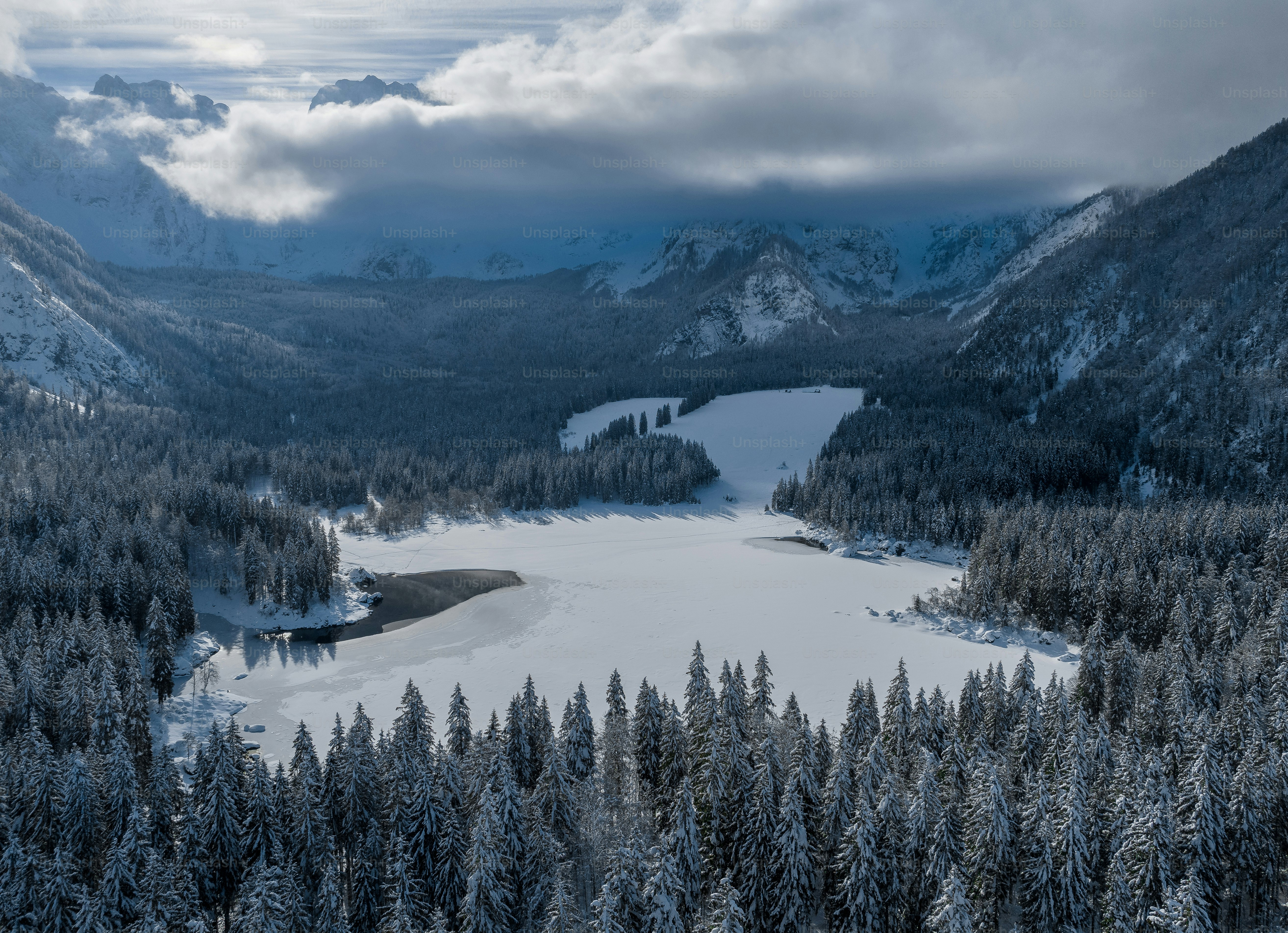 A view of a lake surrounded by snow covered mountains photo – Popular ...