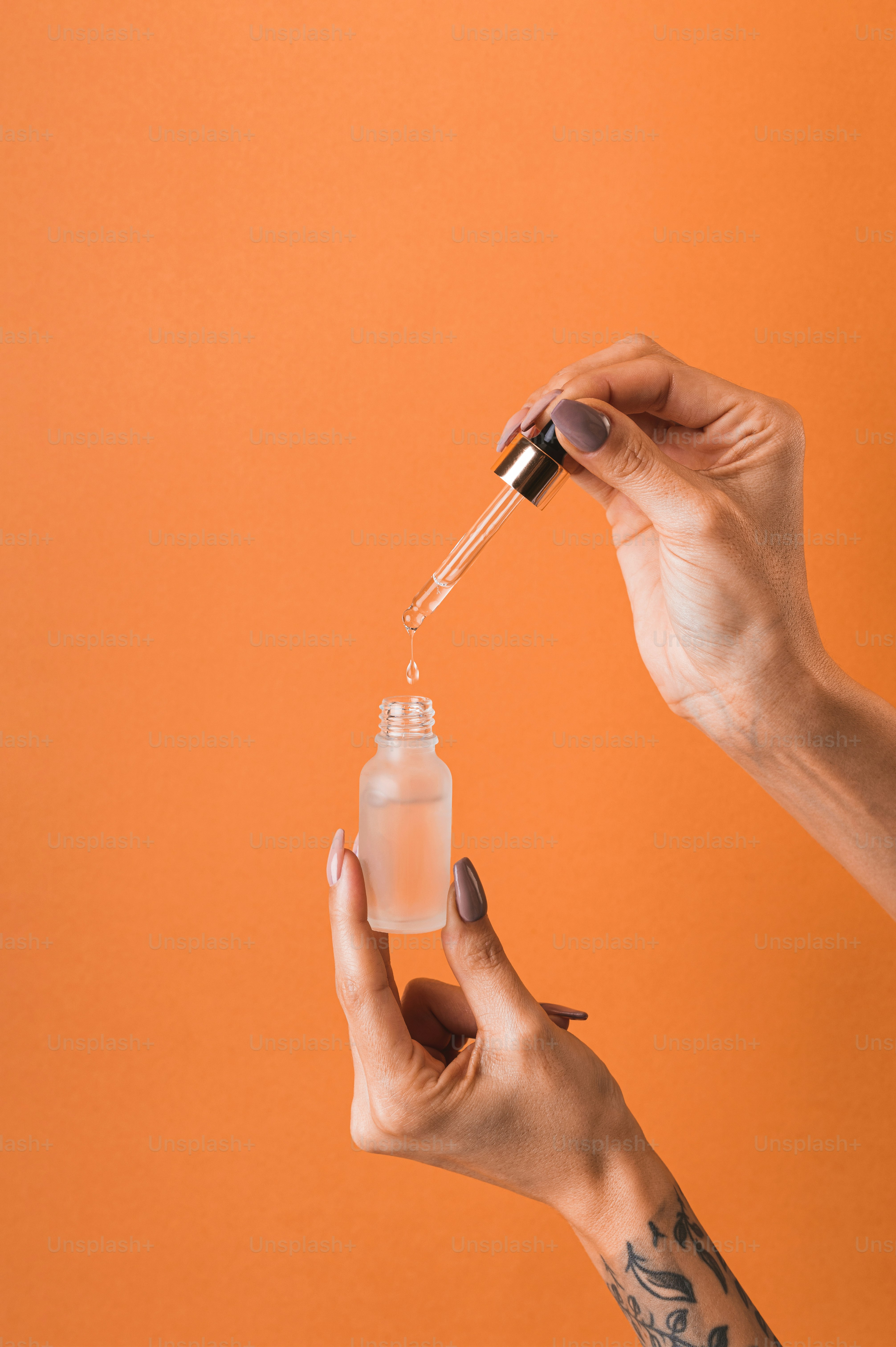 A person is holding a small bottle with a dropper photo – Cosmetics ...
