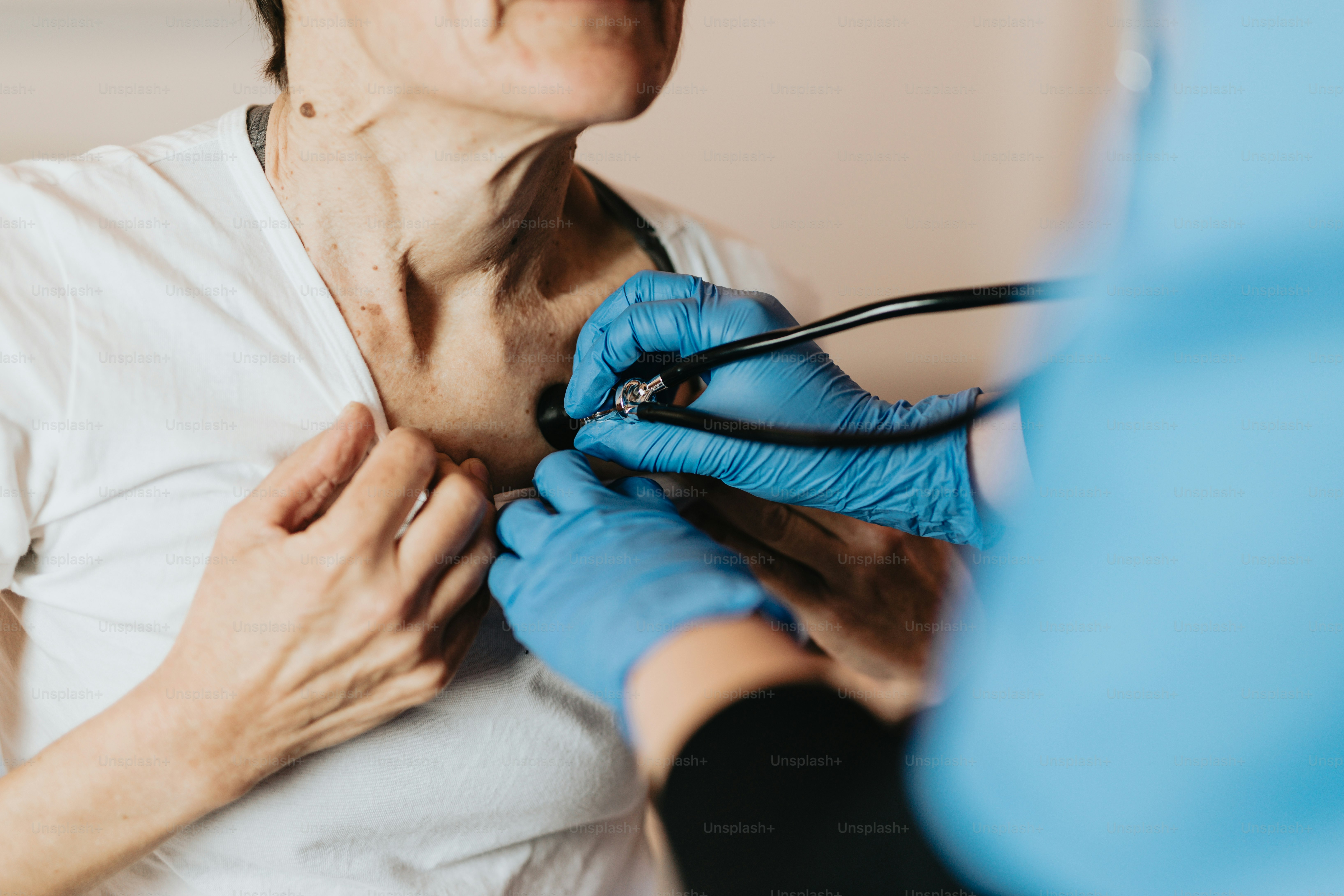 A woman getting her chest examined by a doctor photo – Medical Image on ...