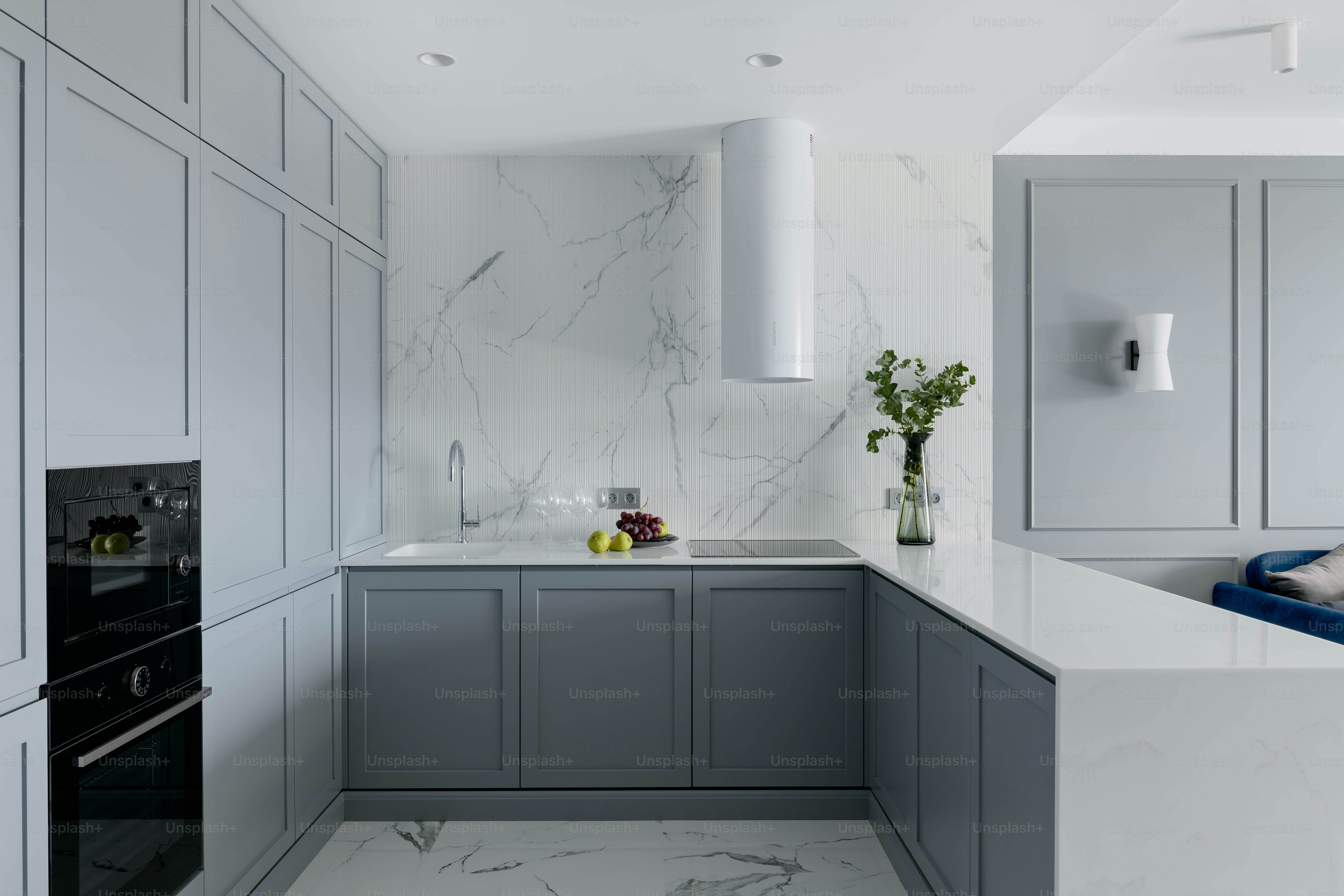 A kitchen with marble counter tops and gray cabinets photo – Interior ...