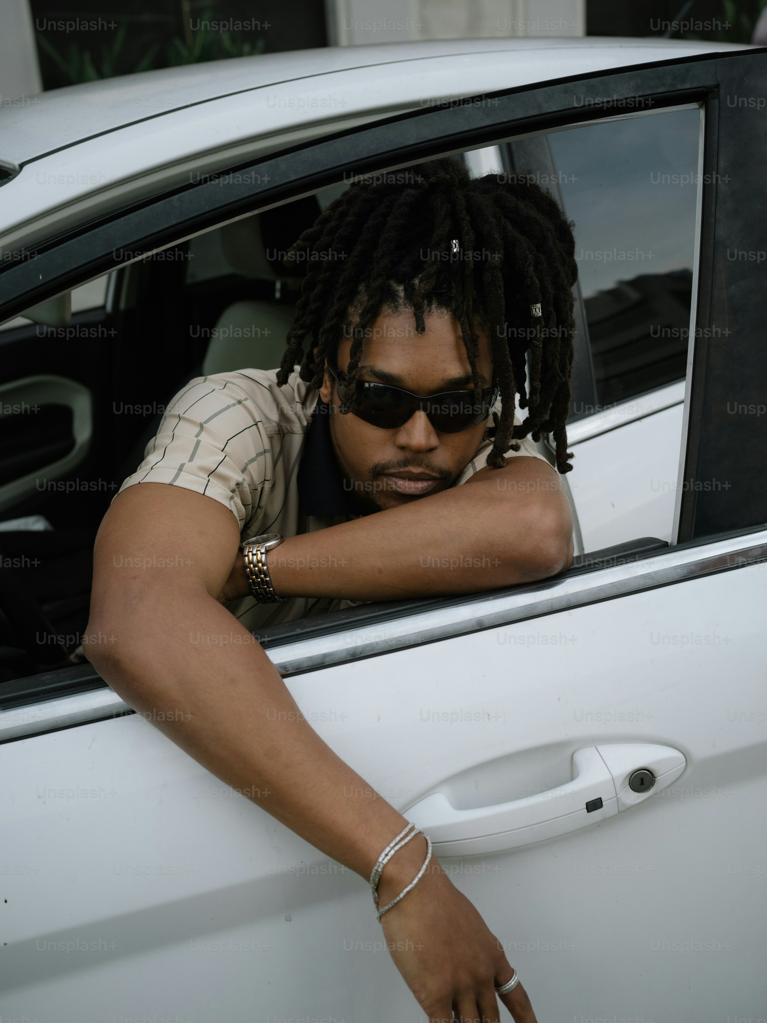A man with dreadlocks leaning out of a car window photo – Portrait ...