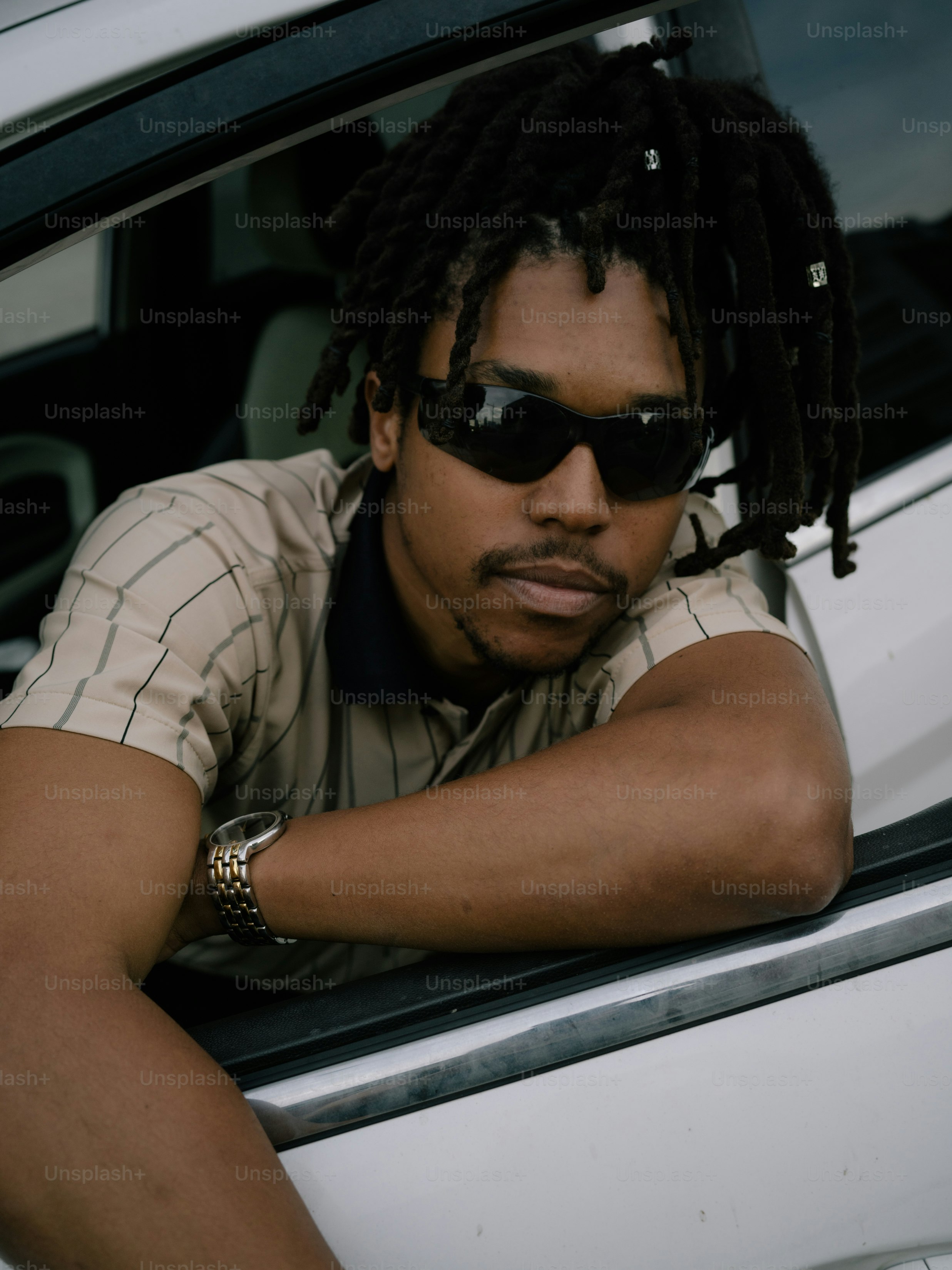 A man with dreadlocks leaning out of a car window photo – Portrait ...
