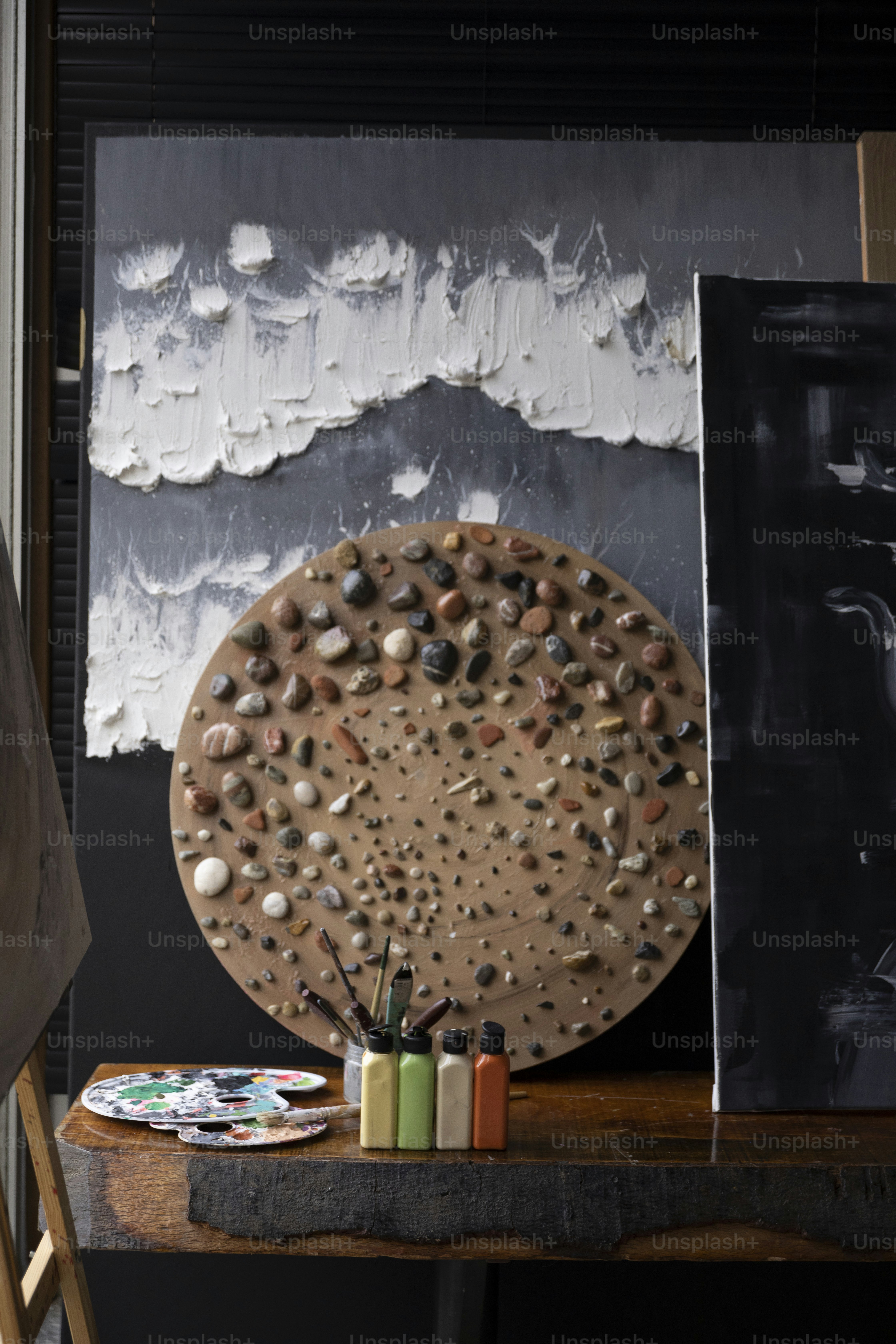 A table with a painting and a painting on it photo – Paintings Image on ...