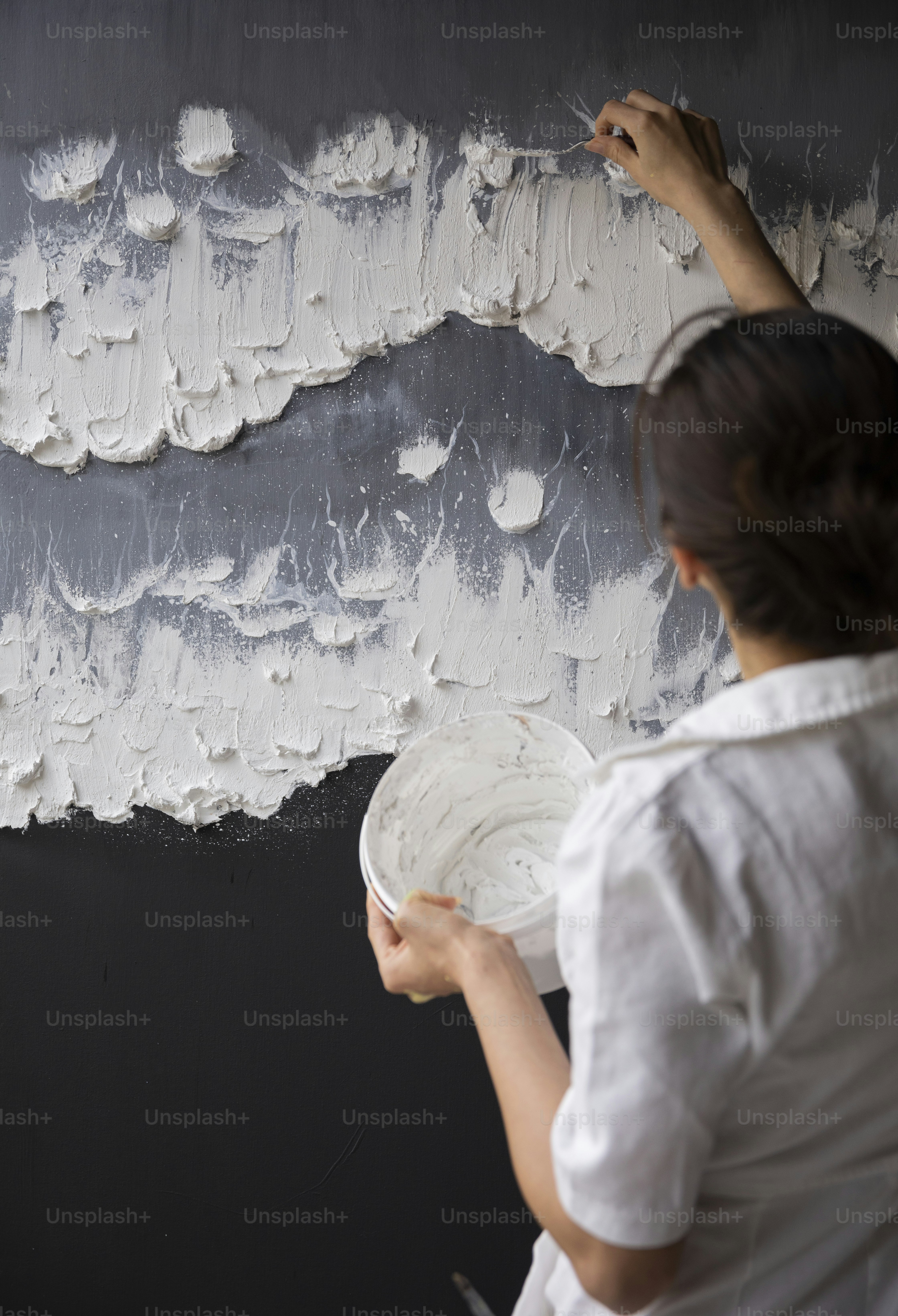 A woman painting a wall with white paint photo – Painter Image on Unsplash