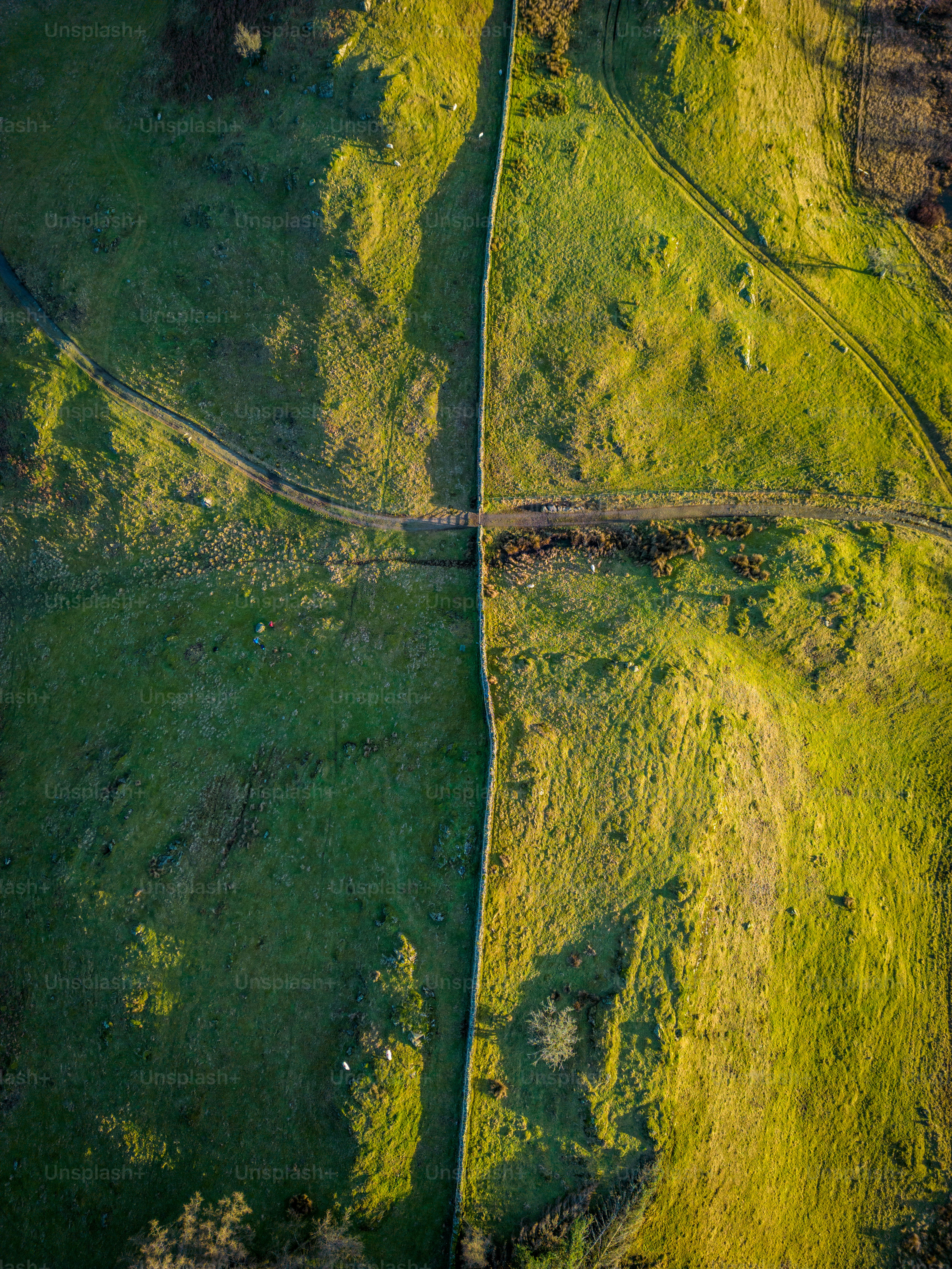 An aerial view of a grassy field with a train track photo – Countryside ...