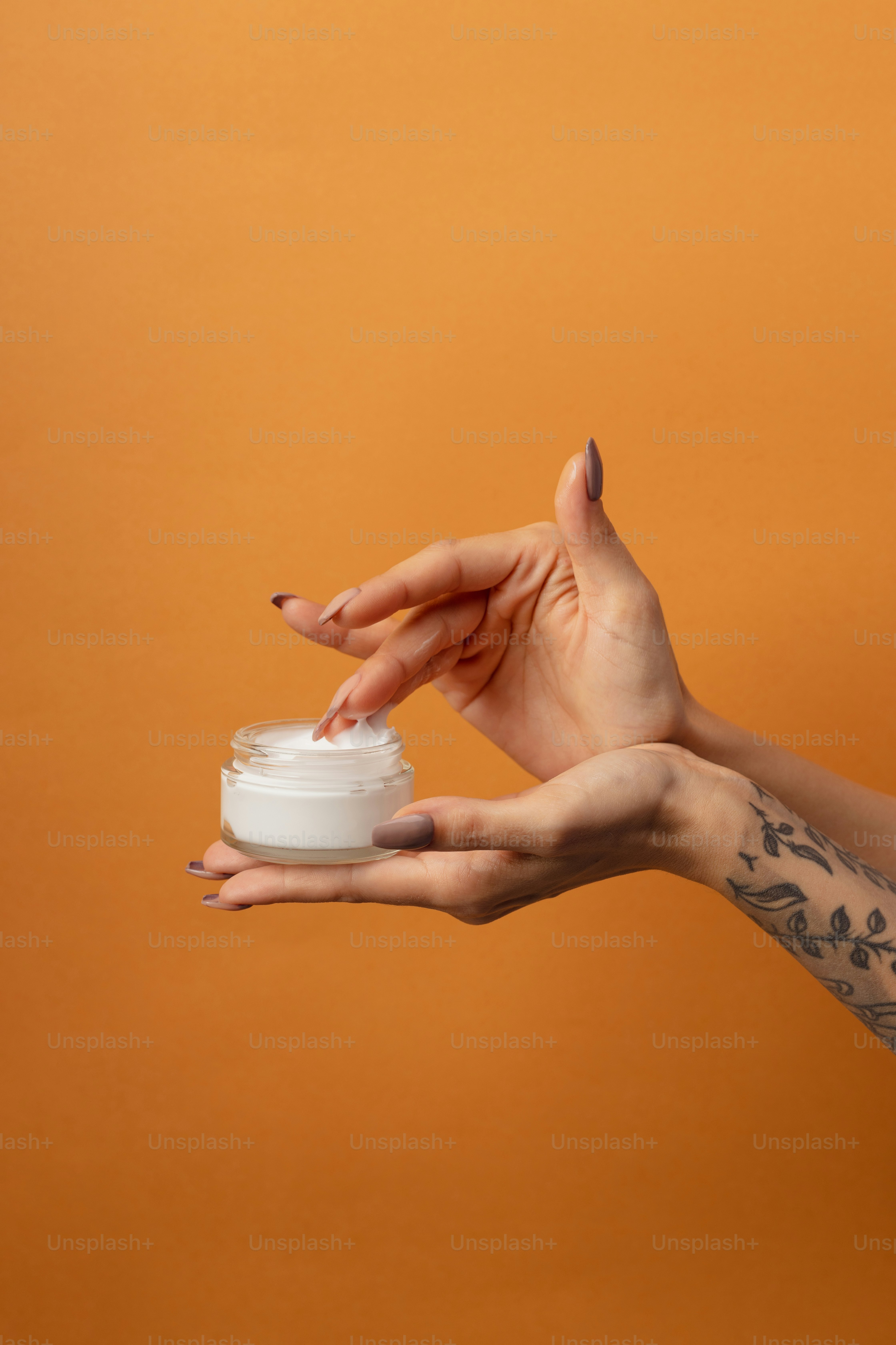 A woman holding a jar of cream in her hand photo – Hand Image on Unsplash